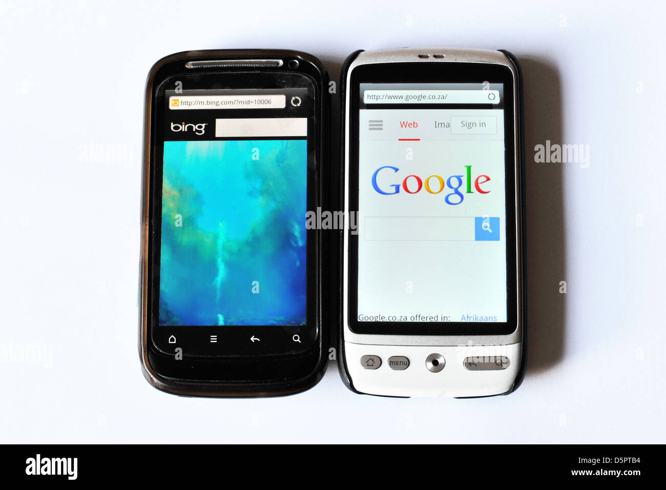Two mobile phone screens showing web pages photographed in a studio ... Two mobile phone screens showing web pages photographed in a studio ...