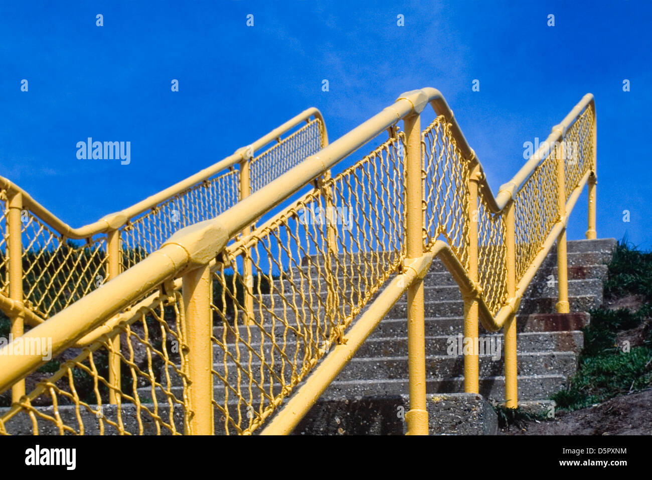steps with bright yellow hand rails against a blue sky Stock Photo - Alamy