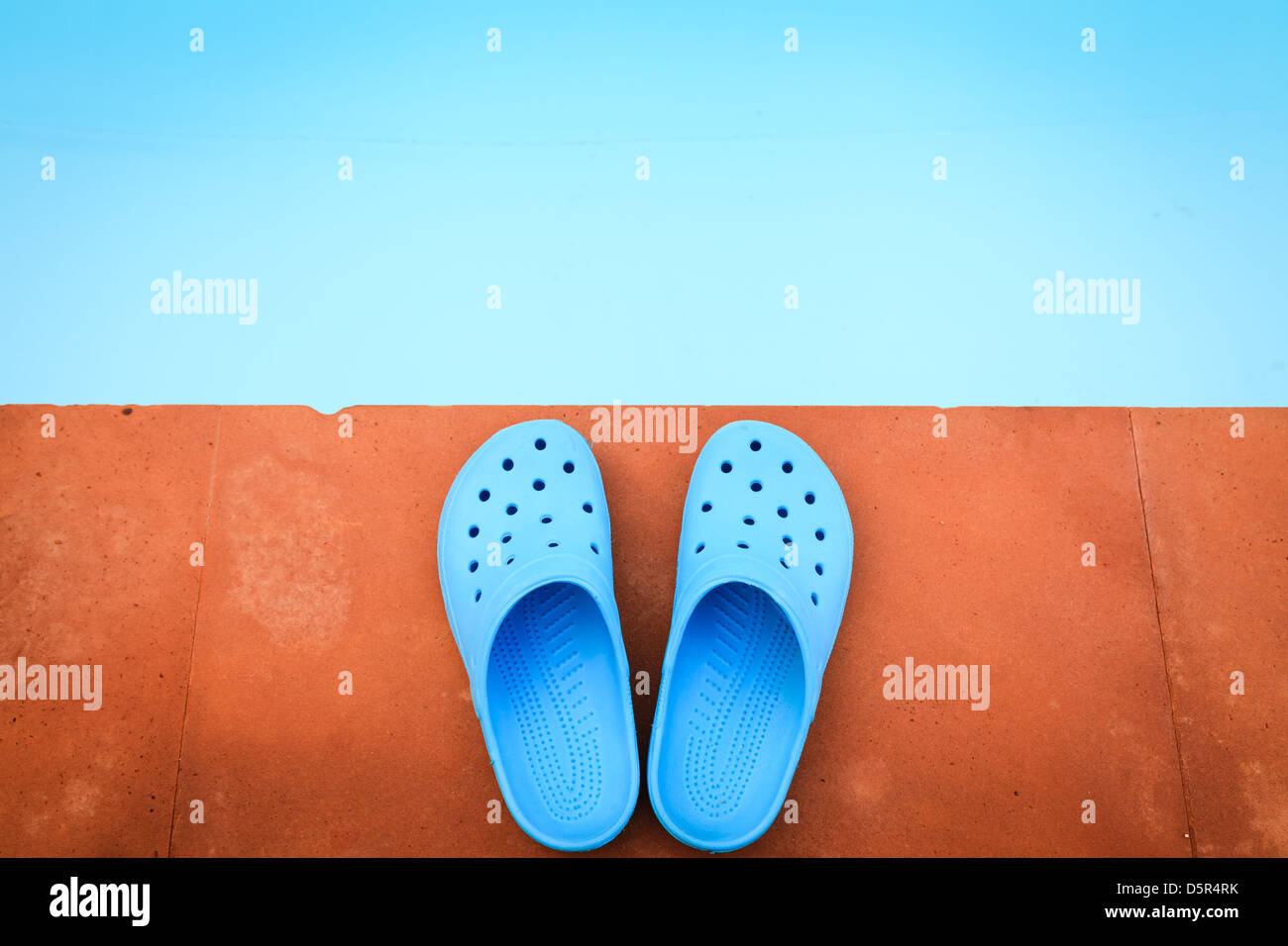 Blue sandals on the poolside of swimming pool Stock Photo - Alamy