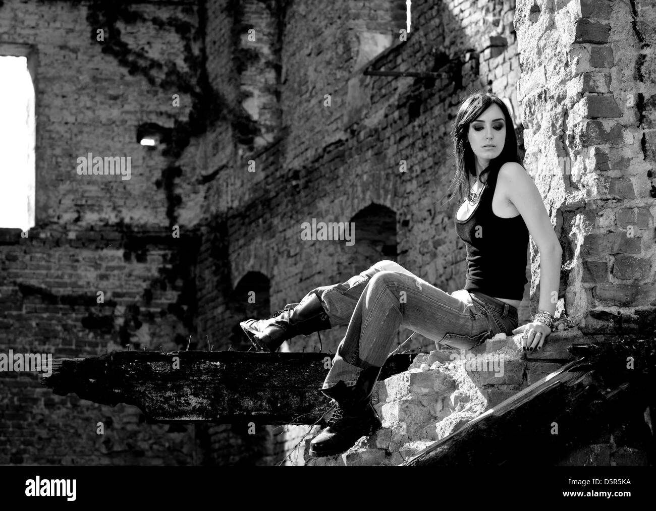 A sensual woman, quite fragile in a desert place looking down, with a ...