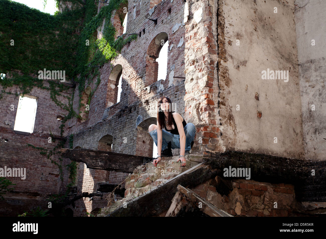 Daring beautiful woman in jeans in an dynamic attitude as if ready to ...