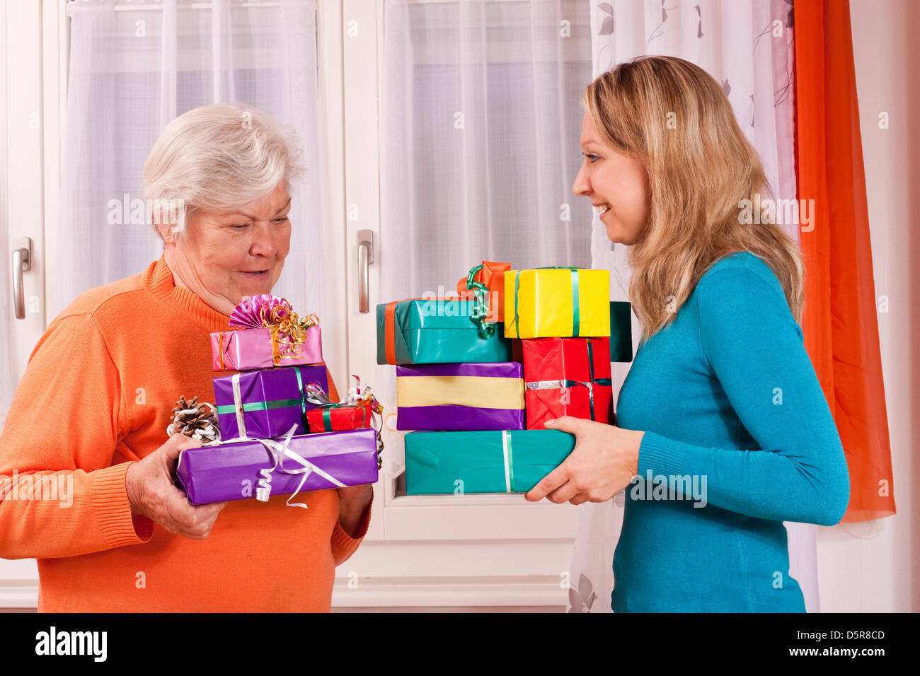 young and old woman are giving presents to each other Stock Photo - Alamy
