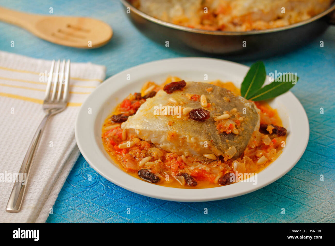 Cod with raisins and pine nuts. Recipe available Stock Photo - Alamy
