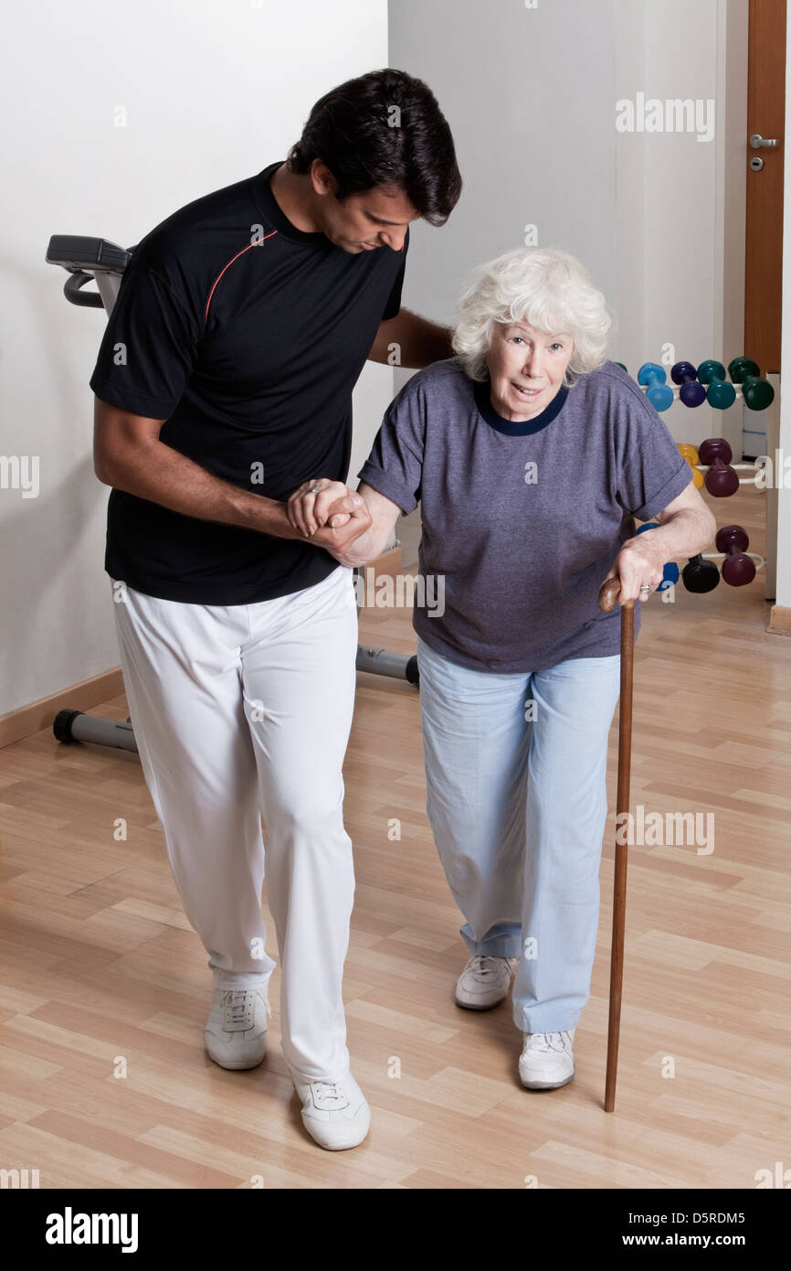 Physical therapist helping man walk hi-res stock photography and images ...