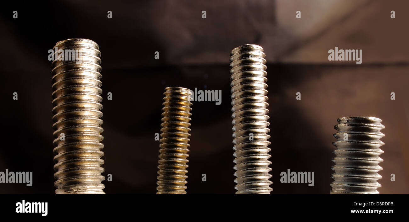 Four threads of screws on a brown background Stock Photo - Alamy