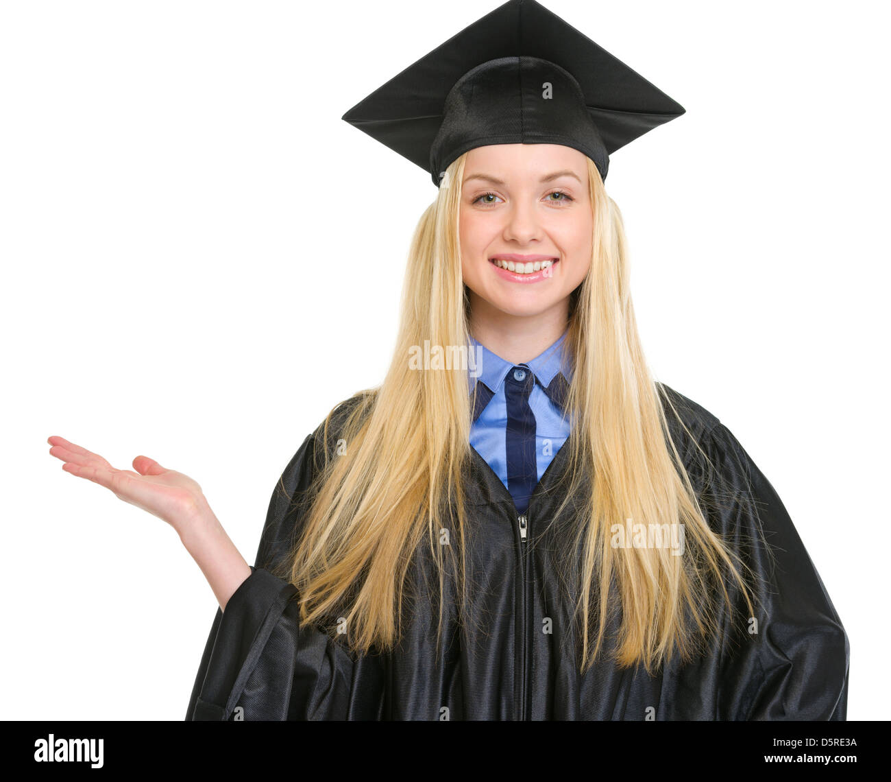Smiling young woman in graduation gown pointing on copy space Stock ...