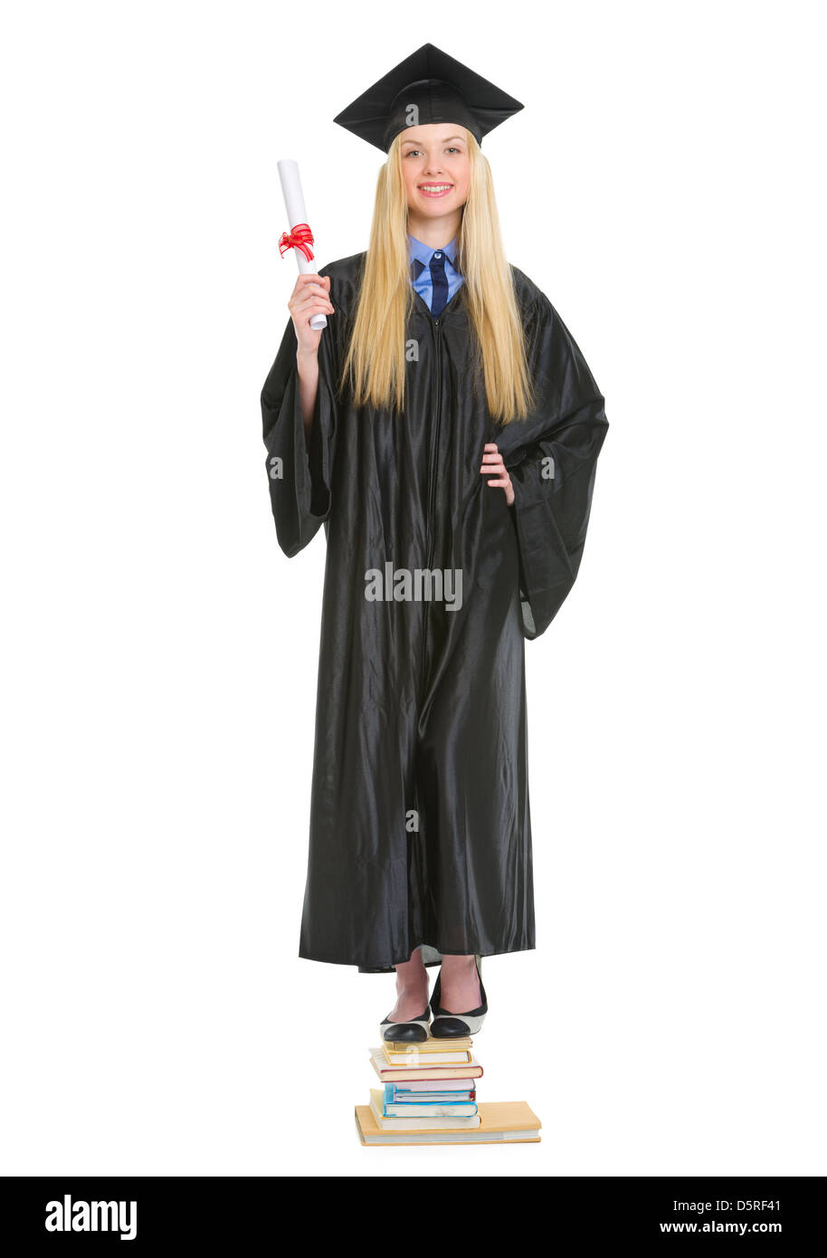 Happy young woman in graduation gown with diploma standing on stack of ...