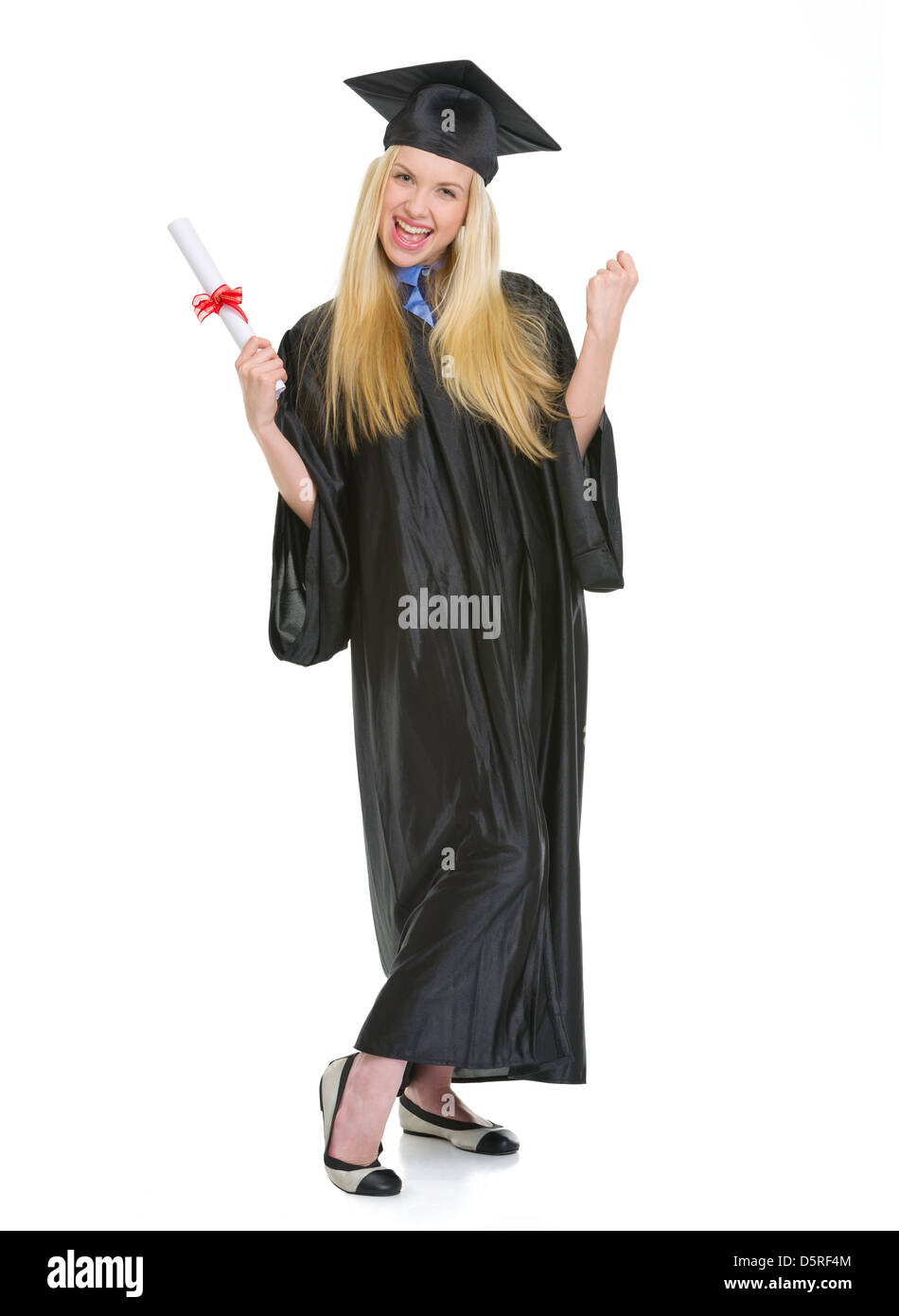 Full length portrait of happy young woman in graduation gown with ...