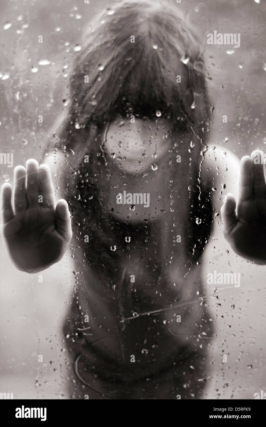 A girl stands leaning against a rainy window Stock Photo - Alamy