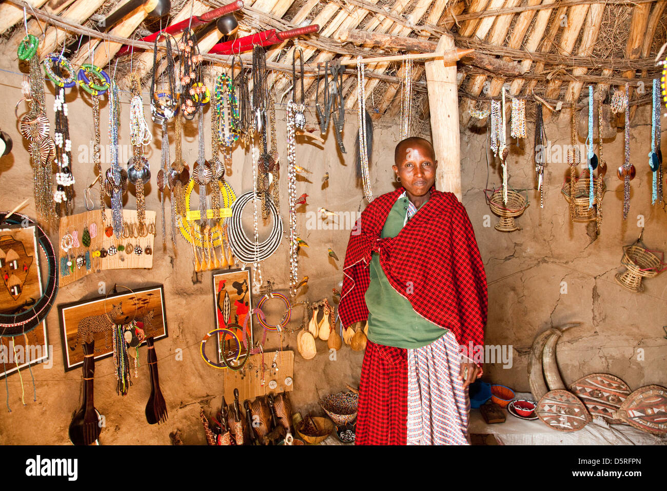 Africa, Tanzania;Maasai women in traditional dress in her souvenir ...