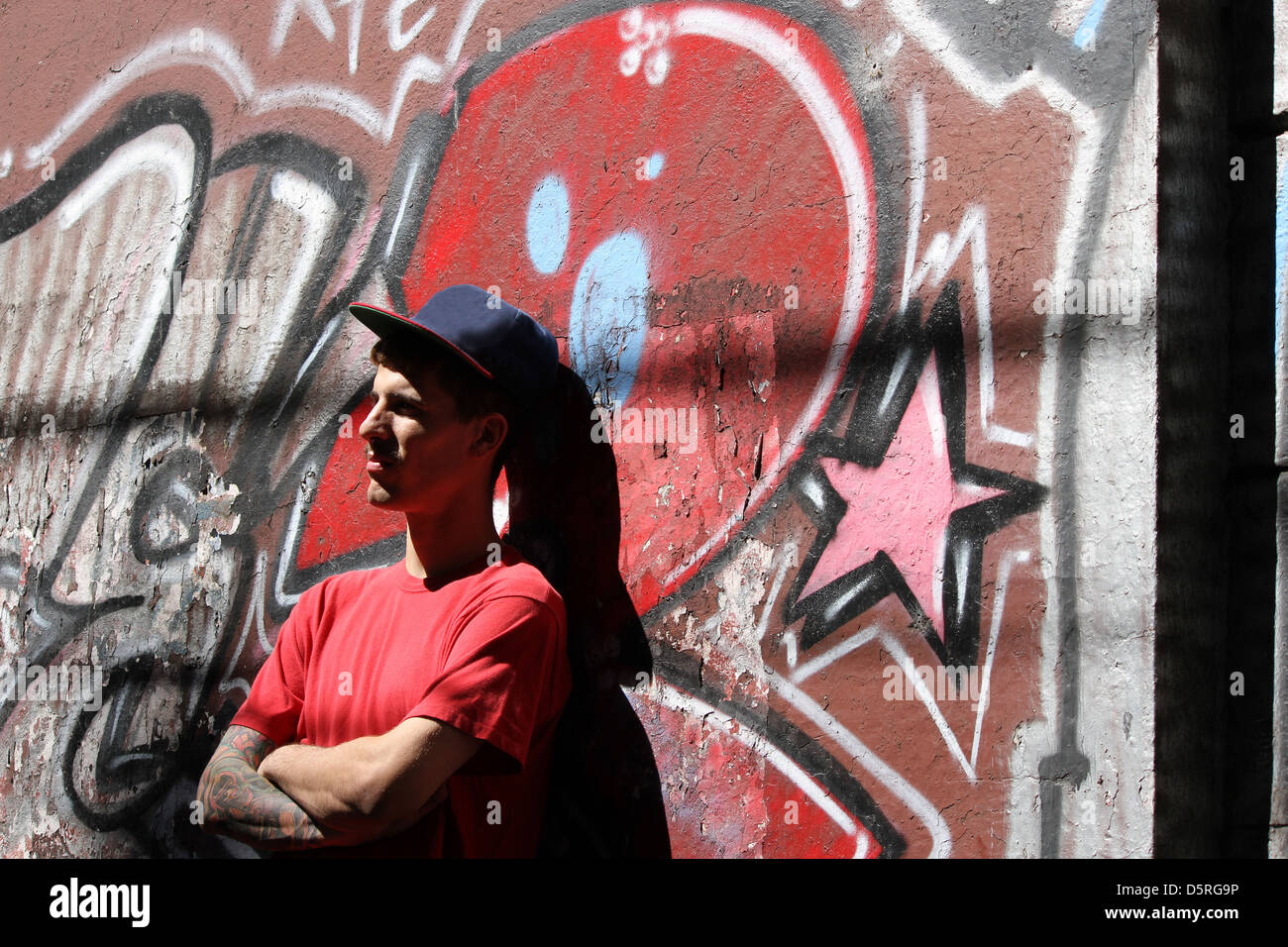 A young Rapper leaning against a wall Stock Photo - Alamy