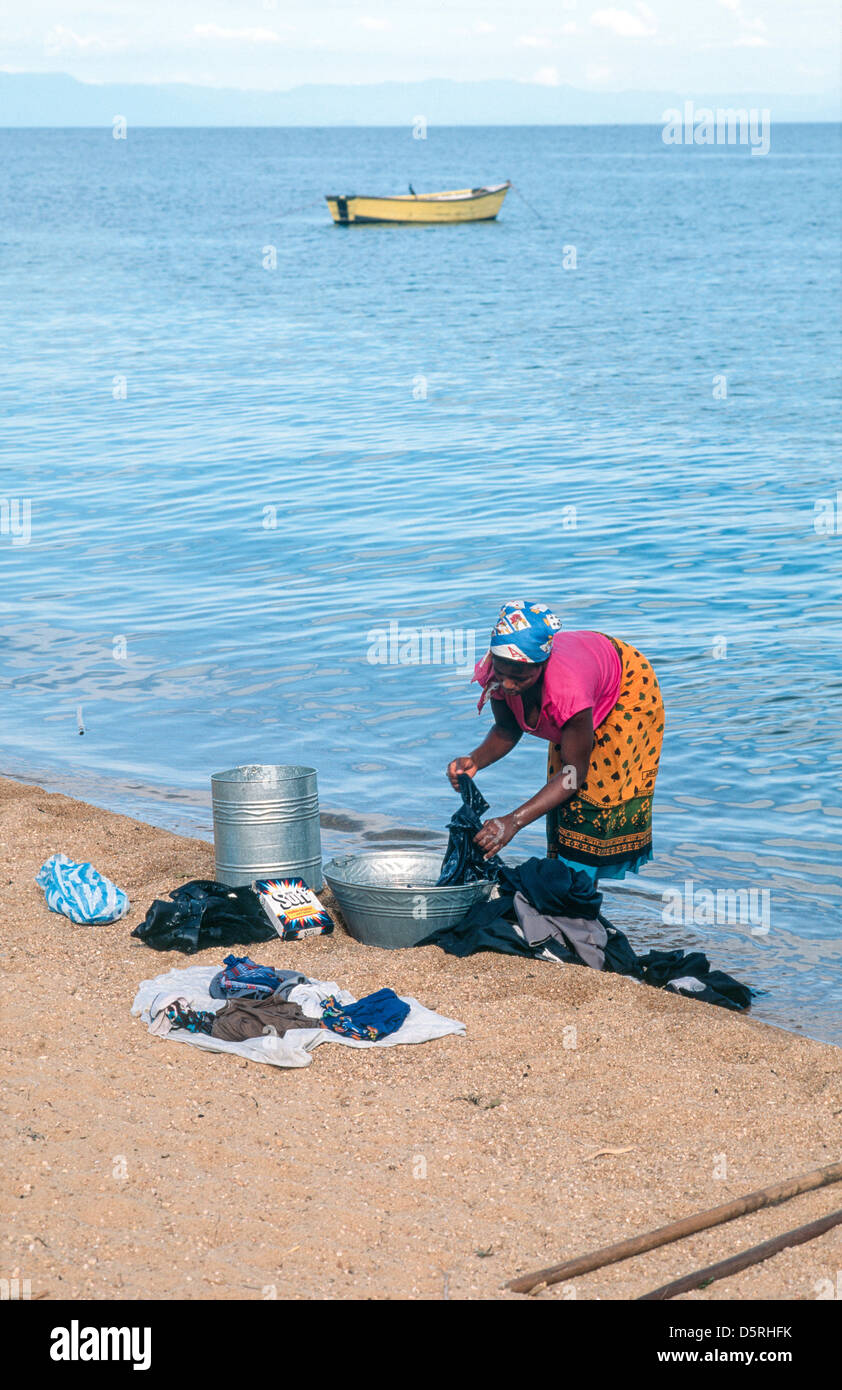 Woman from a lakeside fishing village washing clothes in Lake Malawi ...