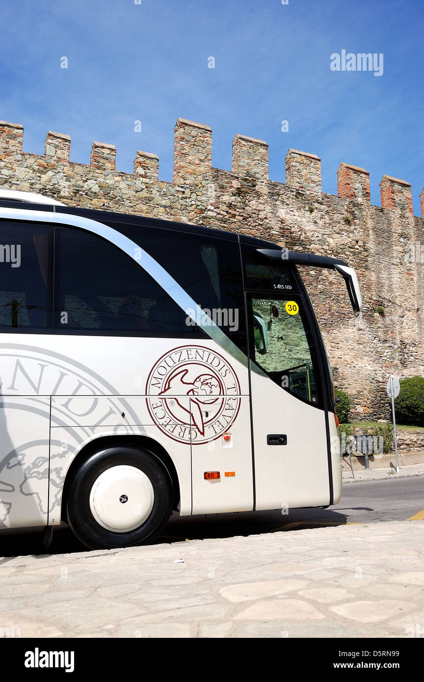 The modern bus for tourists transportation is near Byzantine city walls ...