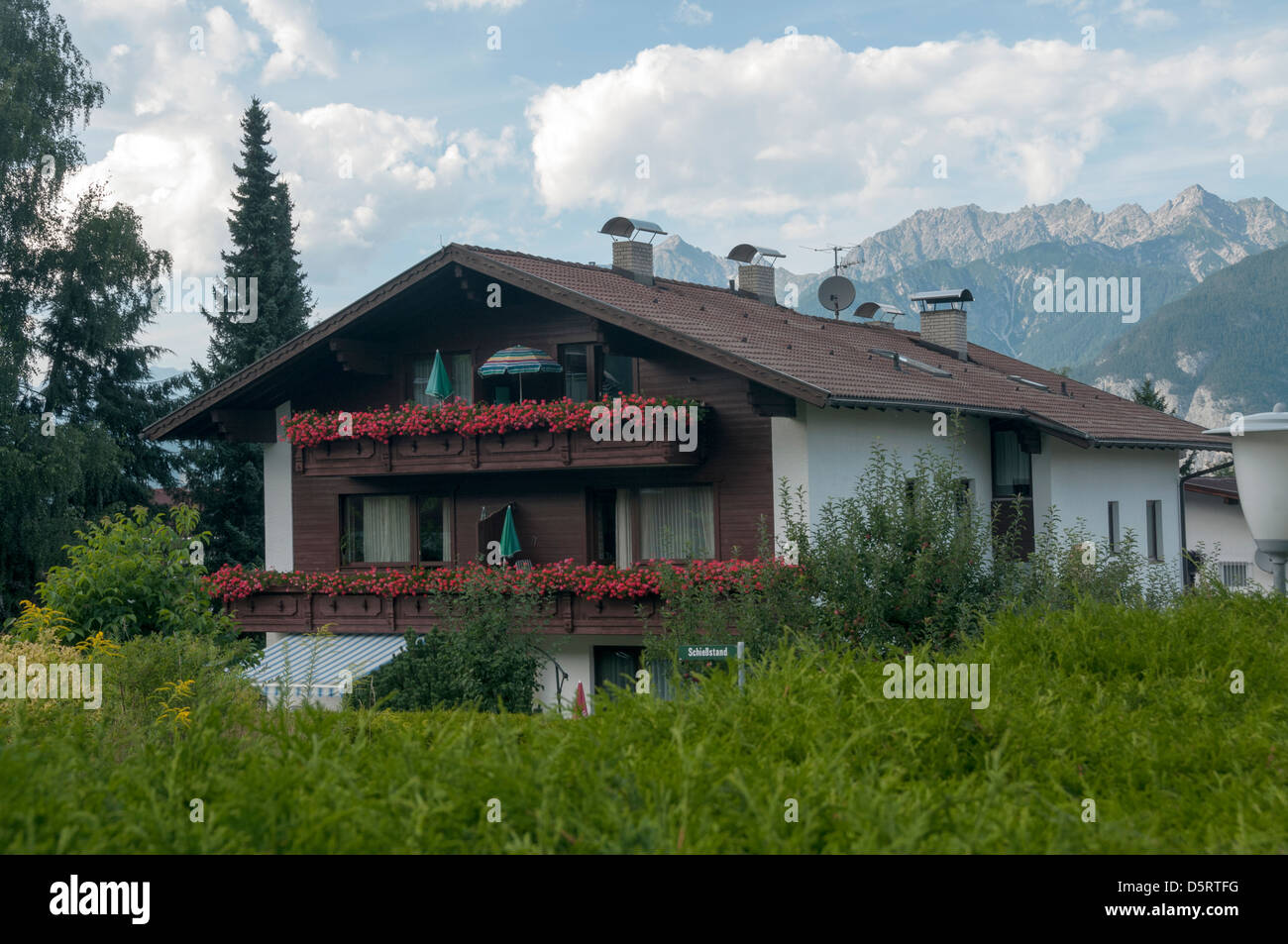 traditonal house in austria with red geranium flowers on the balcony ...