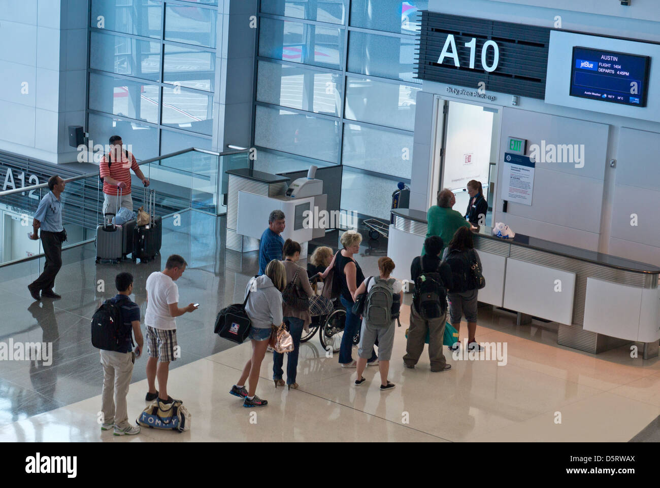 Airline passengers waiting to check in to board flight at concourse ...