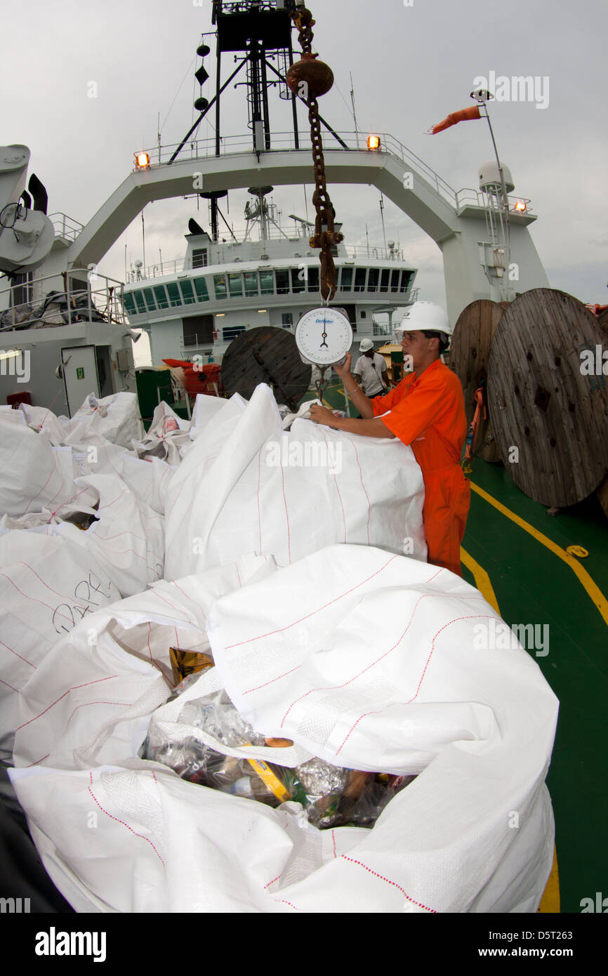 trash bags been lifted and weighted to send ashore for recycling, on ...