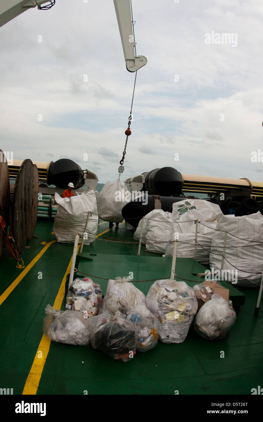 trash bags been lifted and weighted to send ashore for recycling, on ...