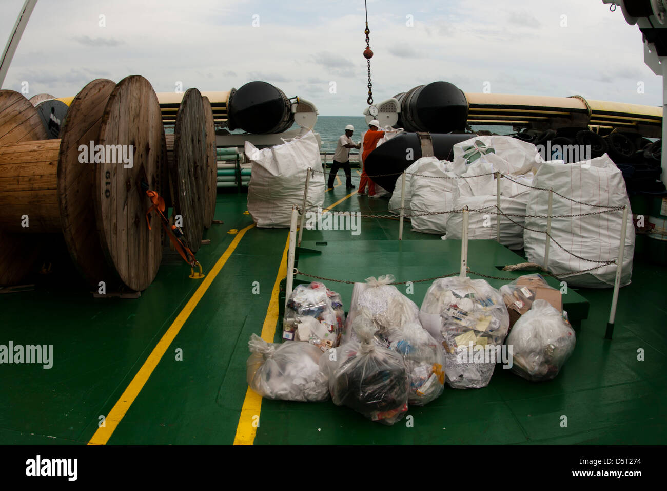 trash bags been lifted and weighted to send ashore for recycling, on ...