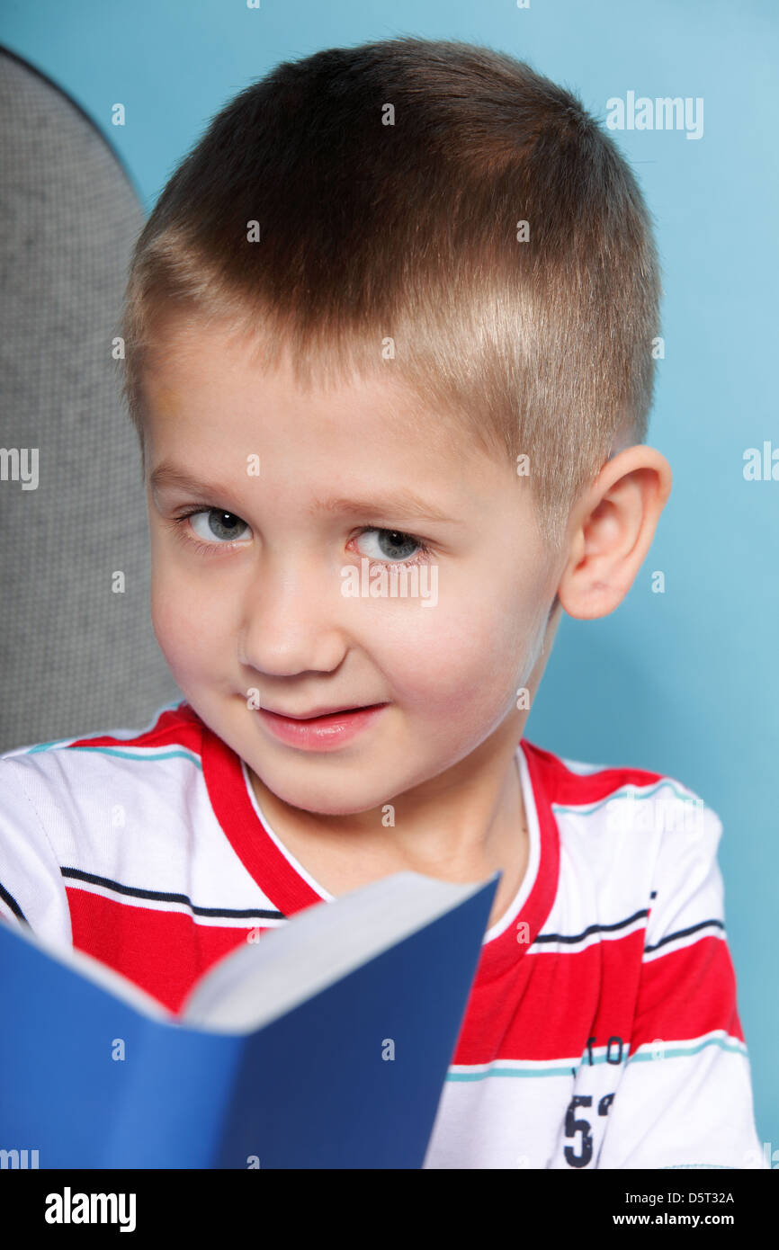boy with a book, child on a blue background holding an open book Stock ...