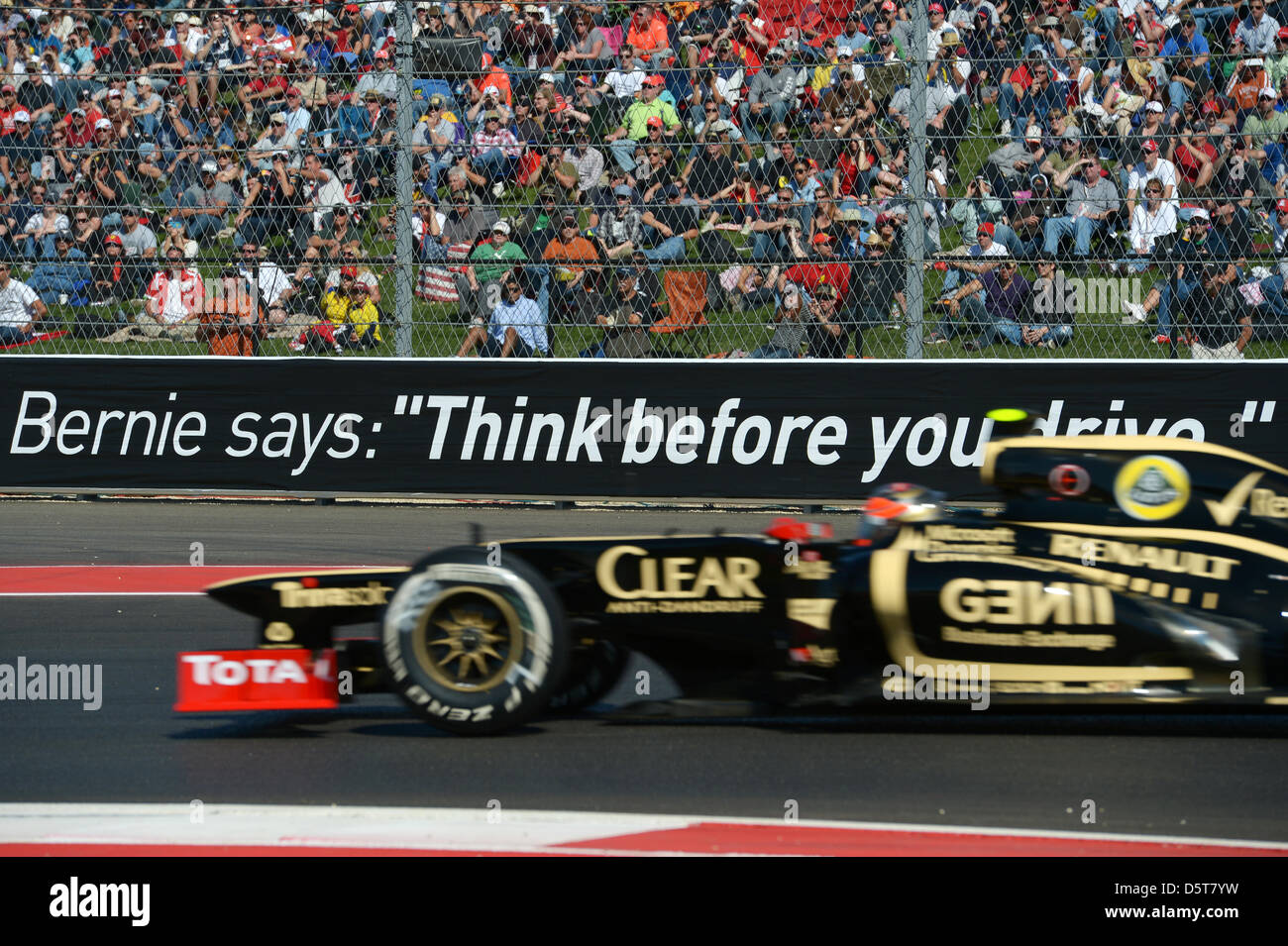 French Formula One driver Romain Grosjean of Lotus passes a sign saying ...