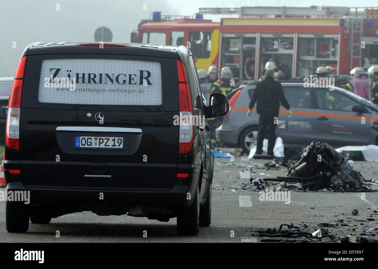 Police officers and firefighters stand in front of cars involved in an ...