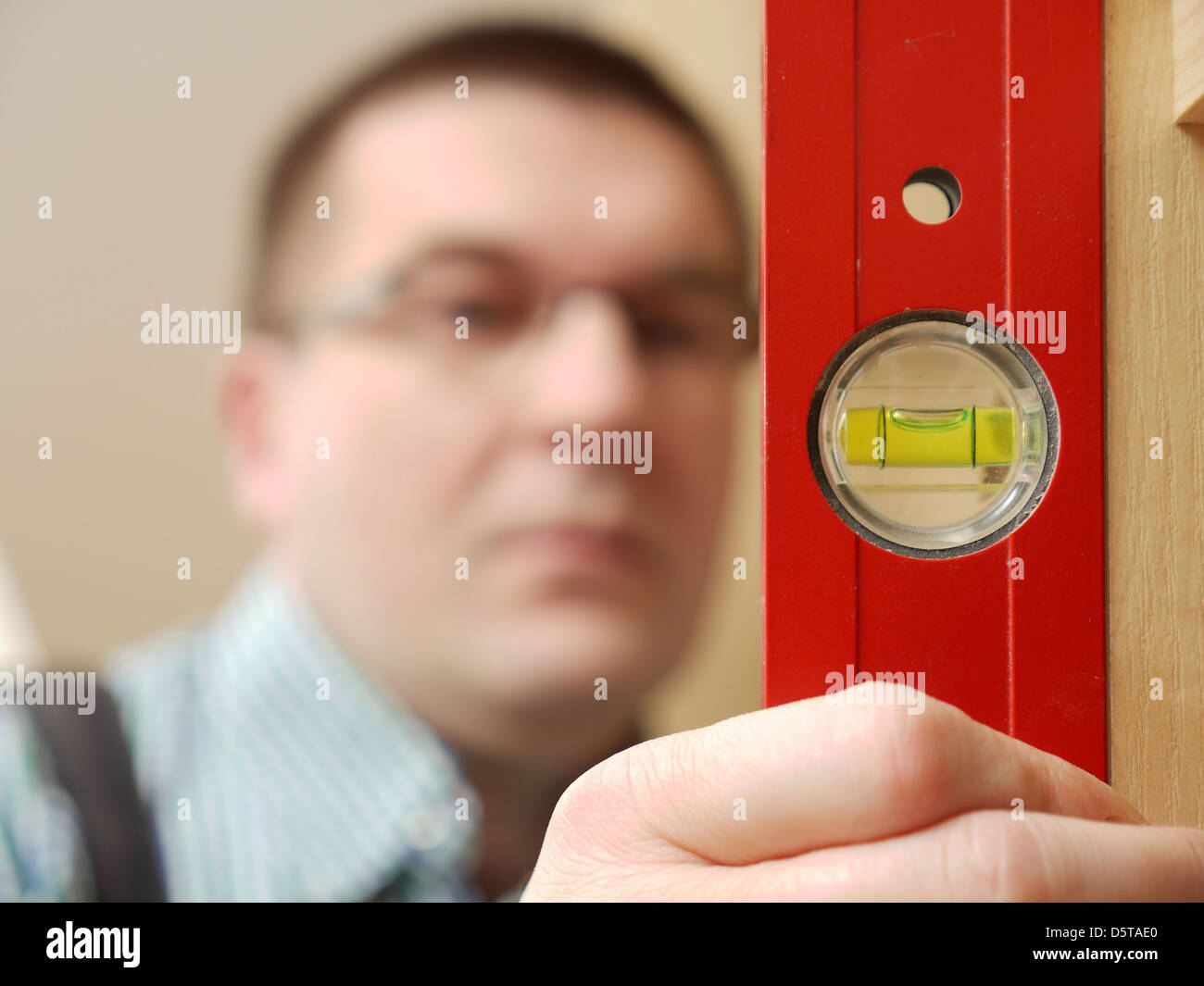 Closeup shot of carpenter looking at spirit level gauge to check ...