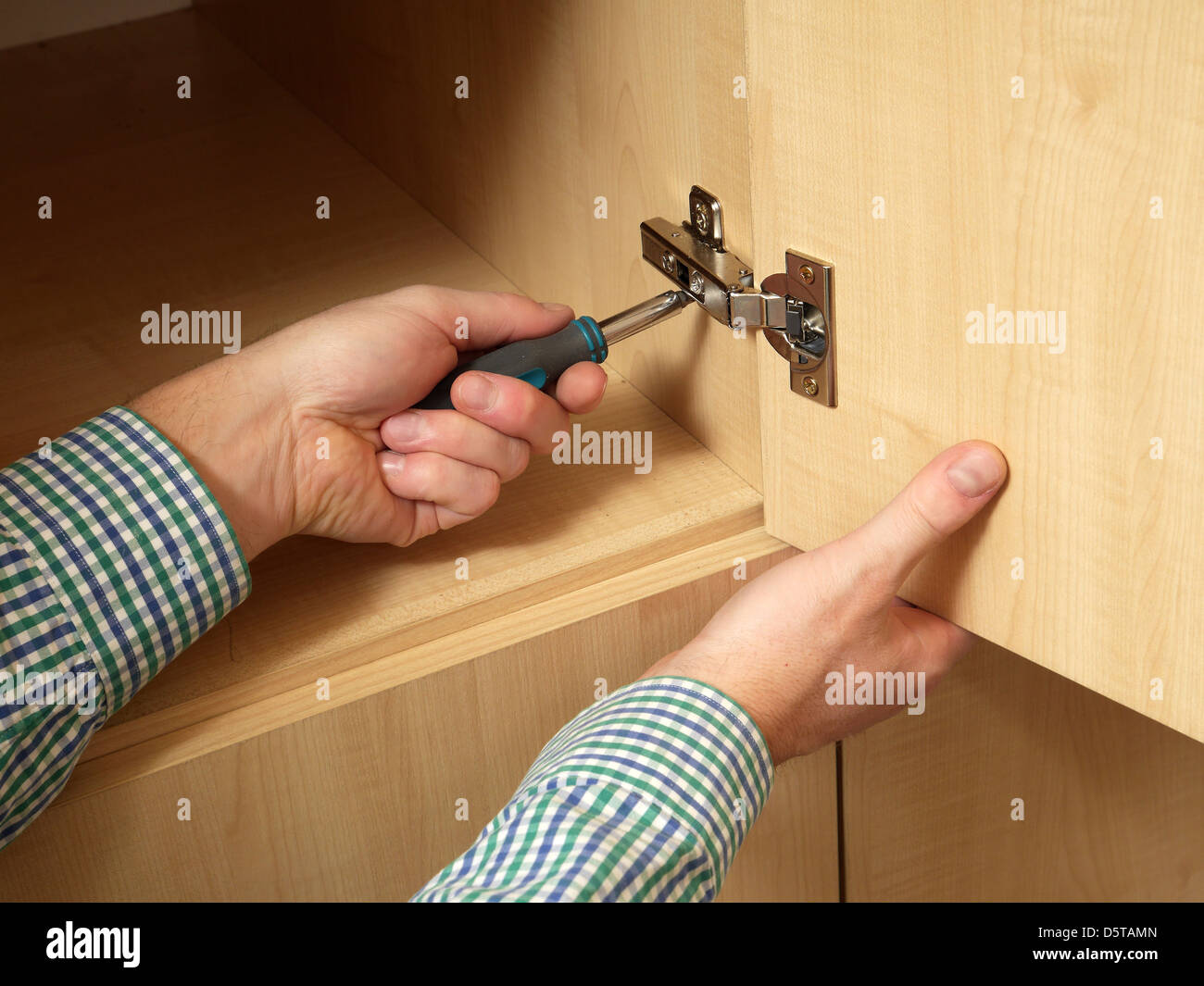 Carpenter fitting wardrobe hinge doors in walk-in closet Stock Photo ...