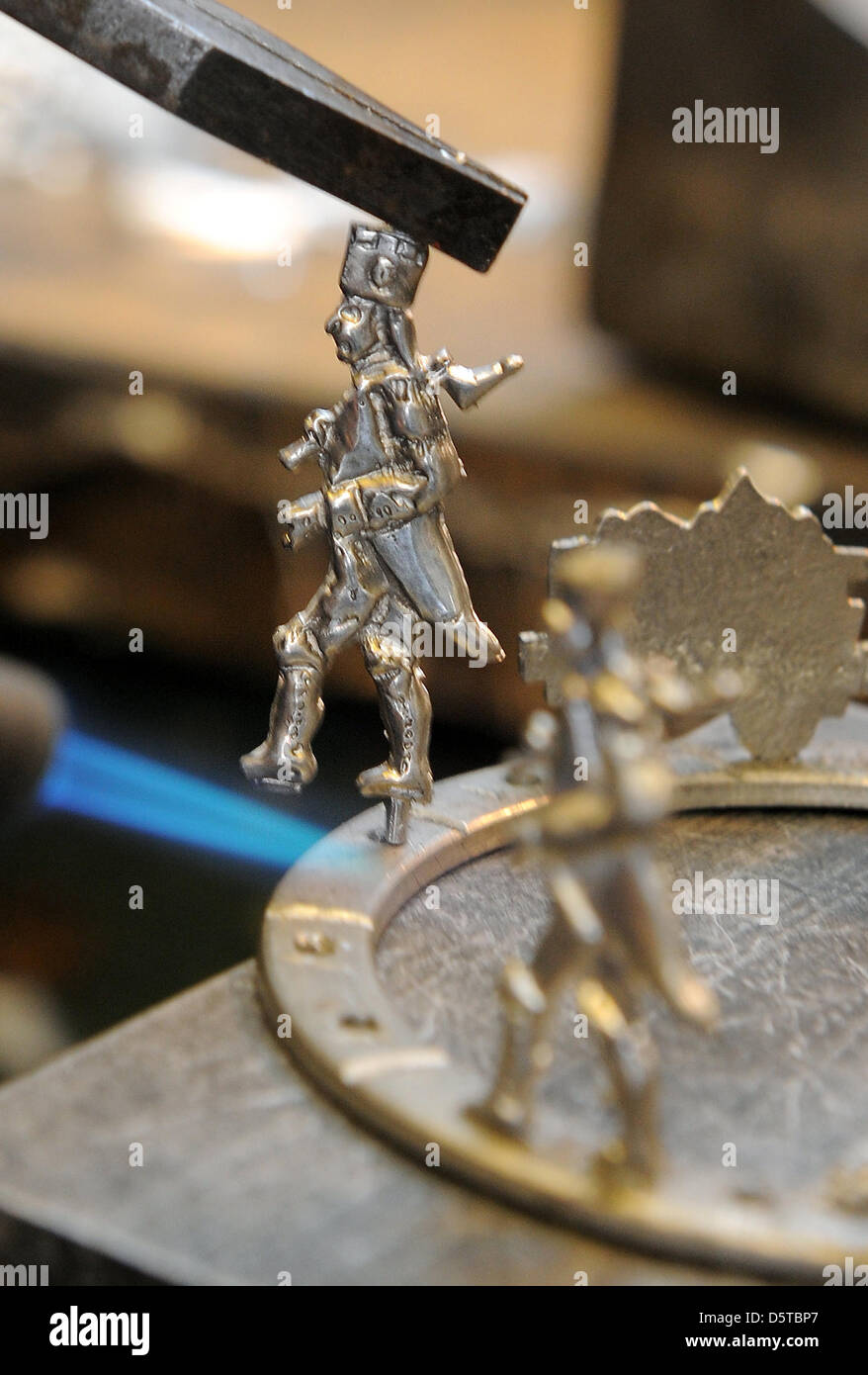 Pewterer Lutz Werner assembles pewter figures for a miner pyramid in ...