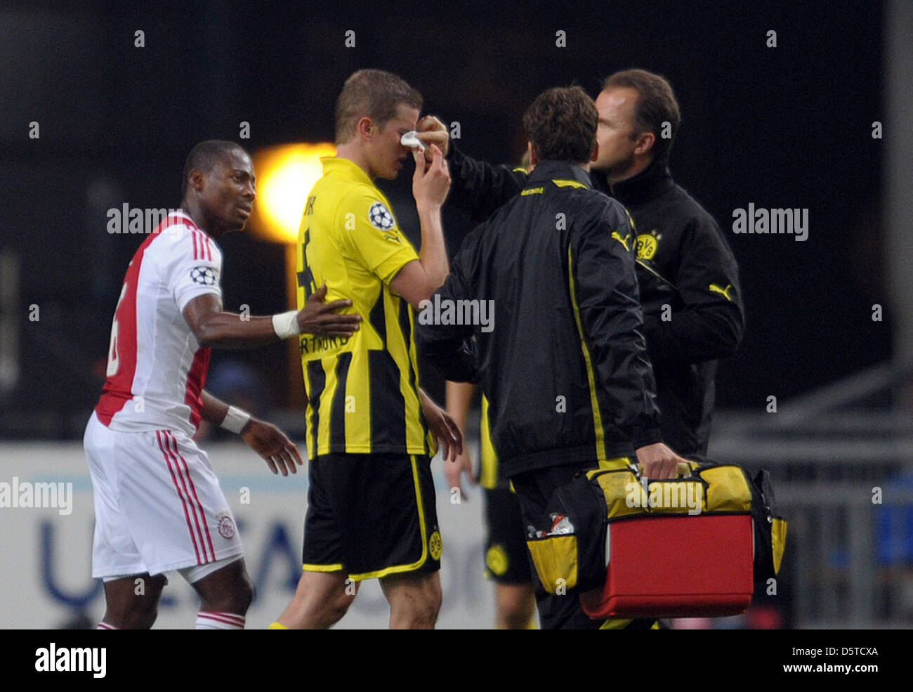 Dortmund's Sven Bender (2-L) receives medical assitance and leaves the ...
