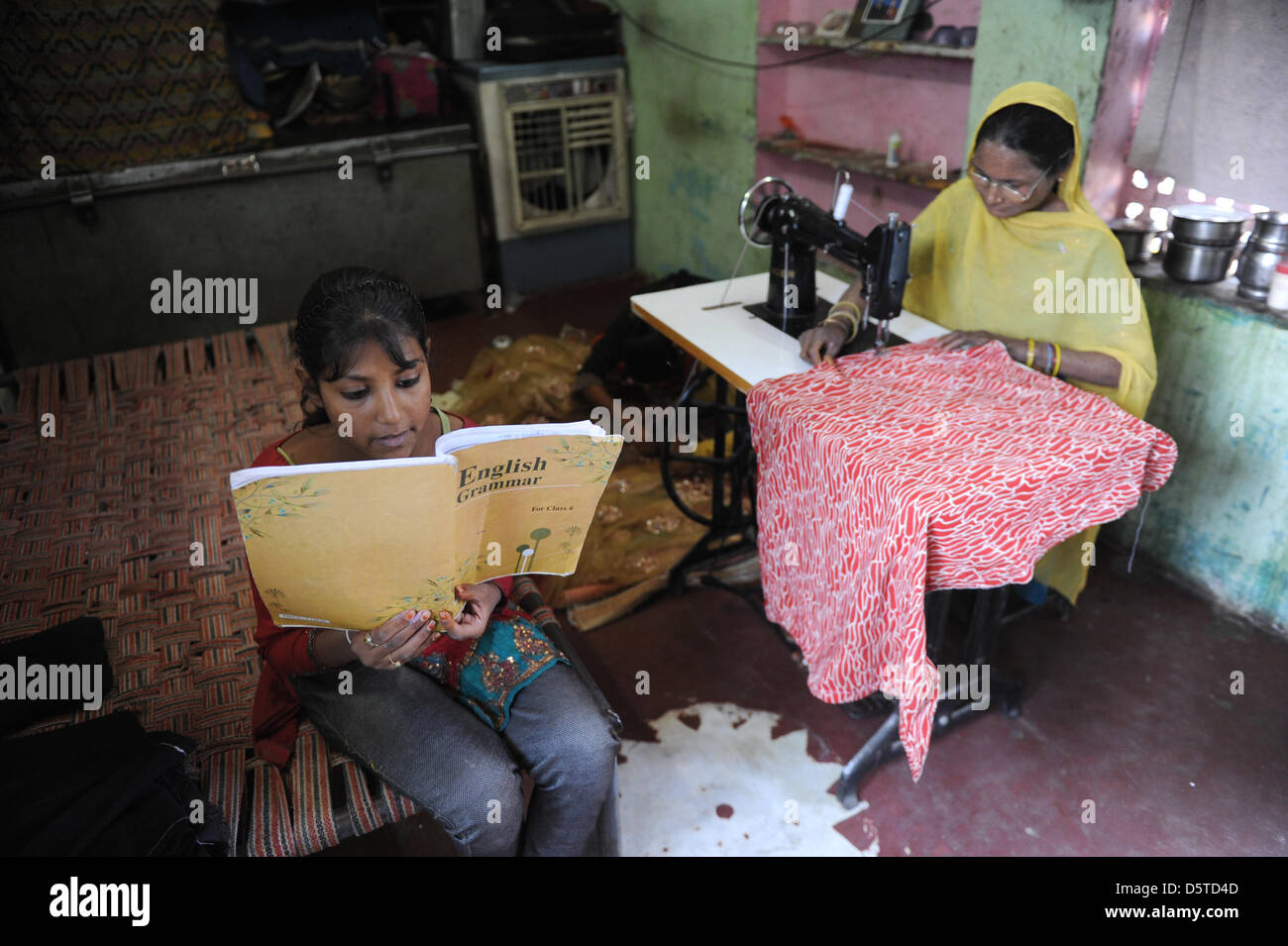 Shayda Bano (r) sews while her daughter Amreen does her English ...