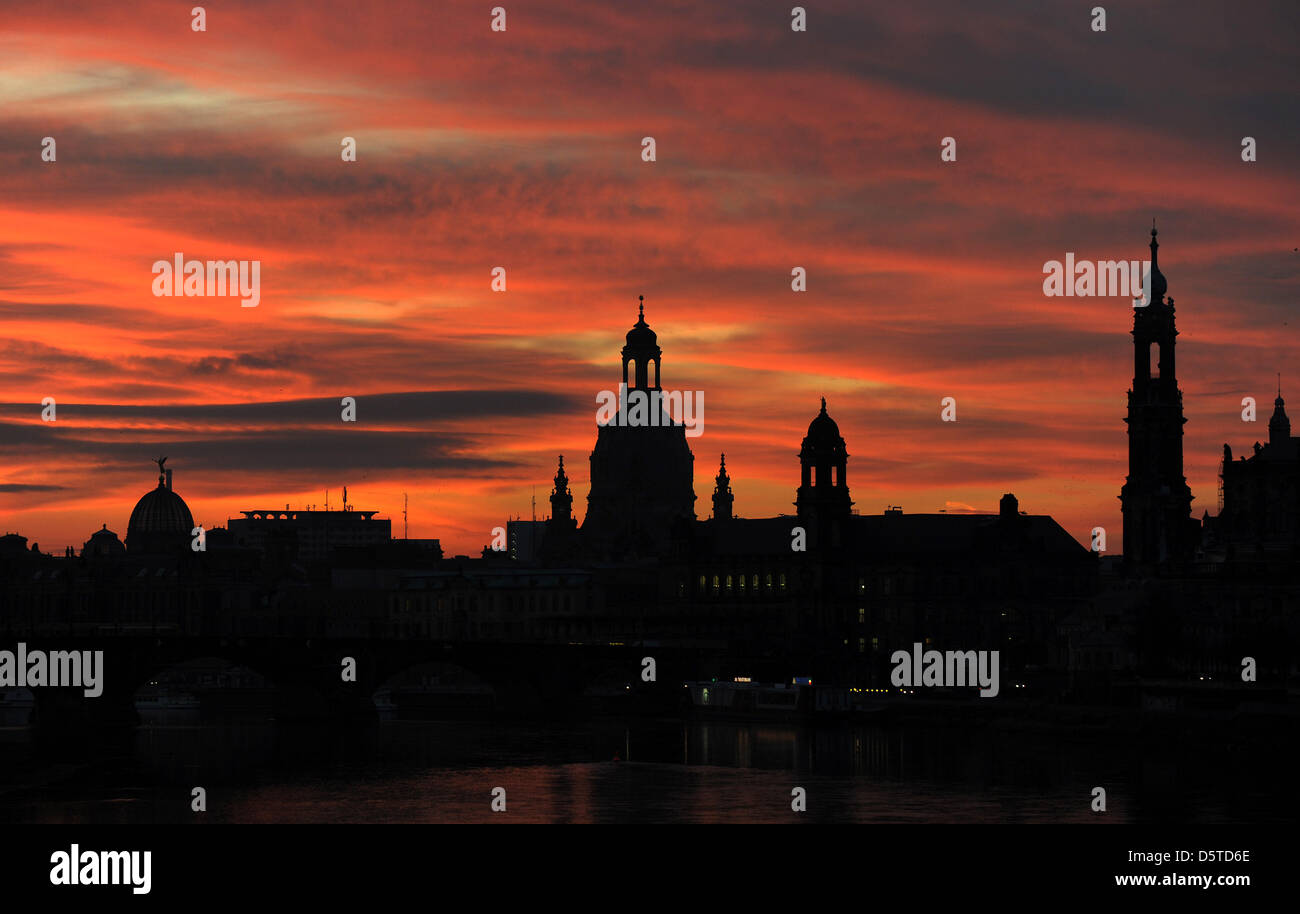 A red morning sky and clouds appear above the city of Dresden at dawn ...