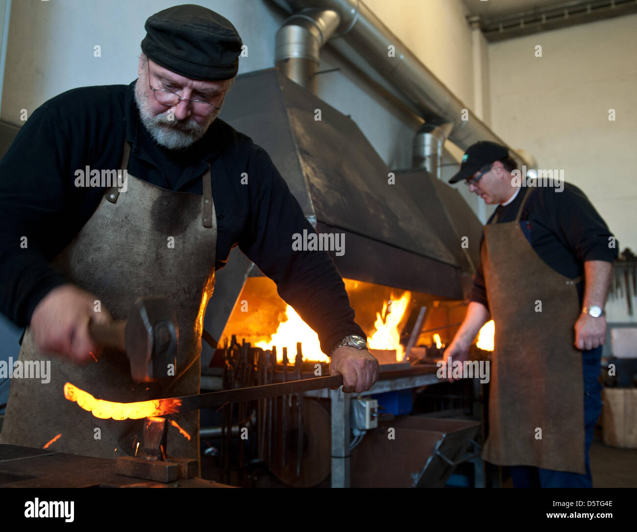 Blacksmith Ruediger Schwenk works on an iron rose with his volunteer ...