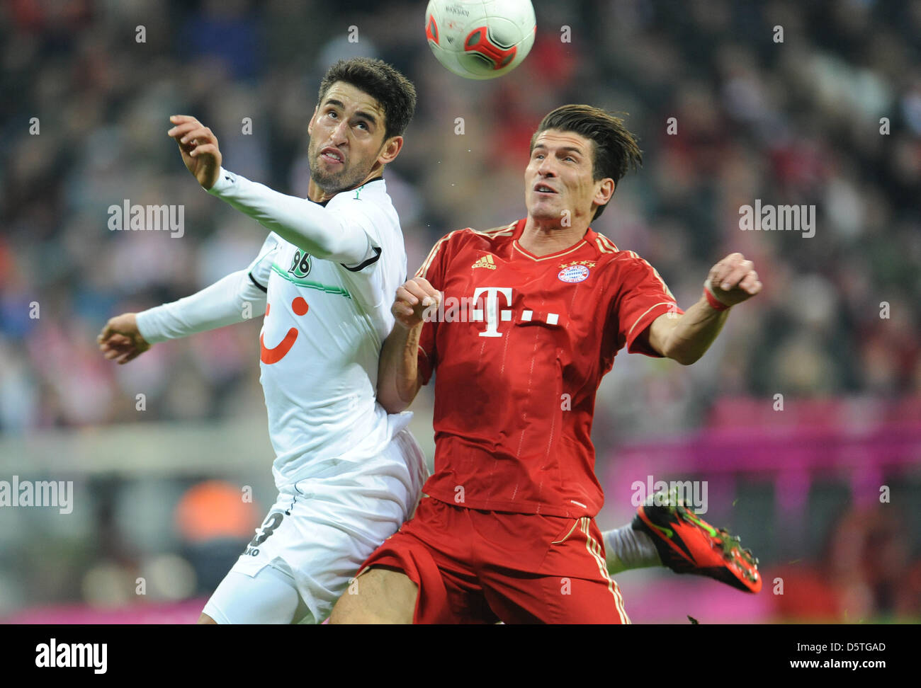 Munich's Mario Gomez (R) viesn for the ball with Hannover's Karim ...