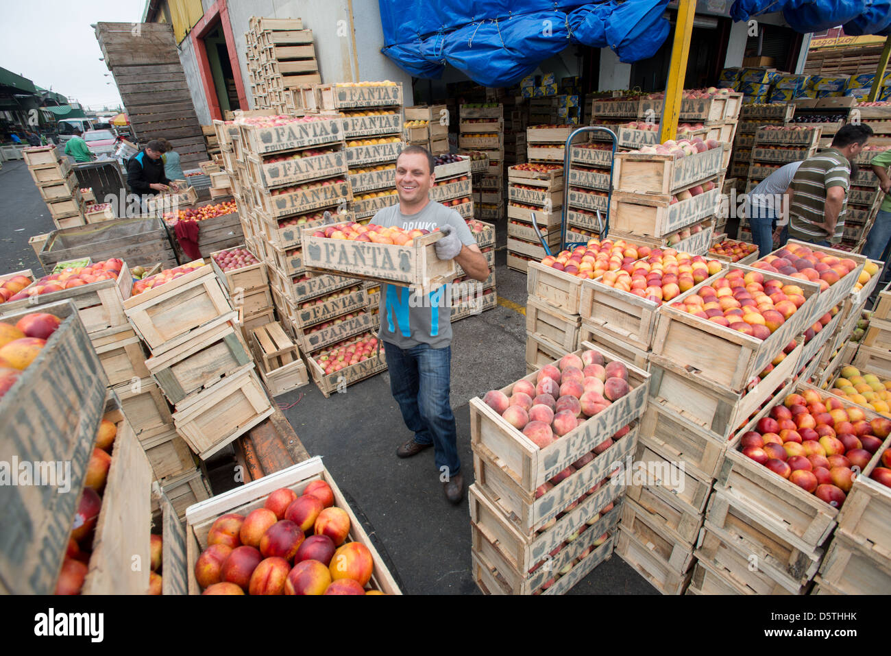 Worker moving crates of fruit at Lo Valledor central wholesale produce ...