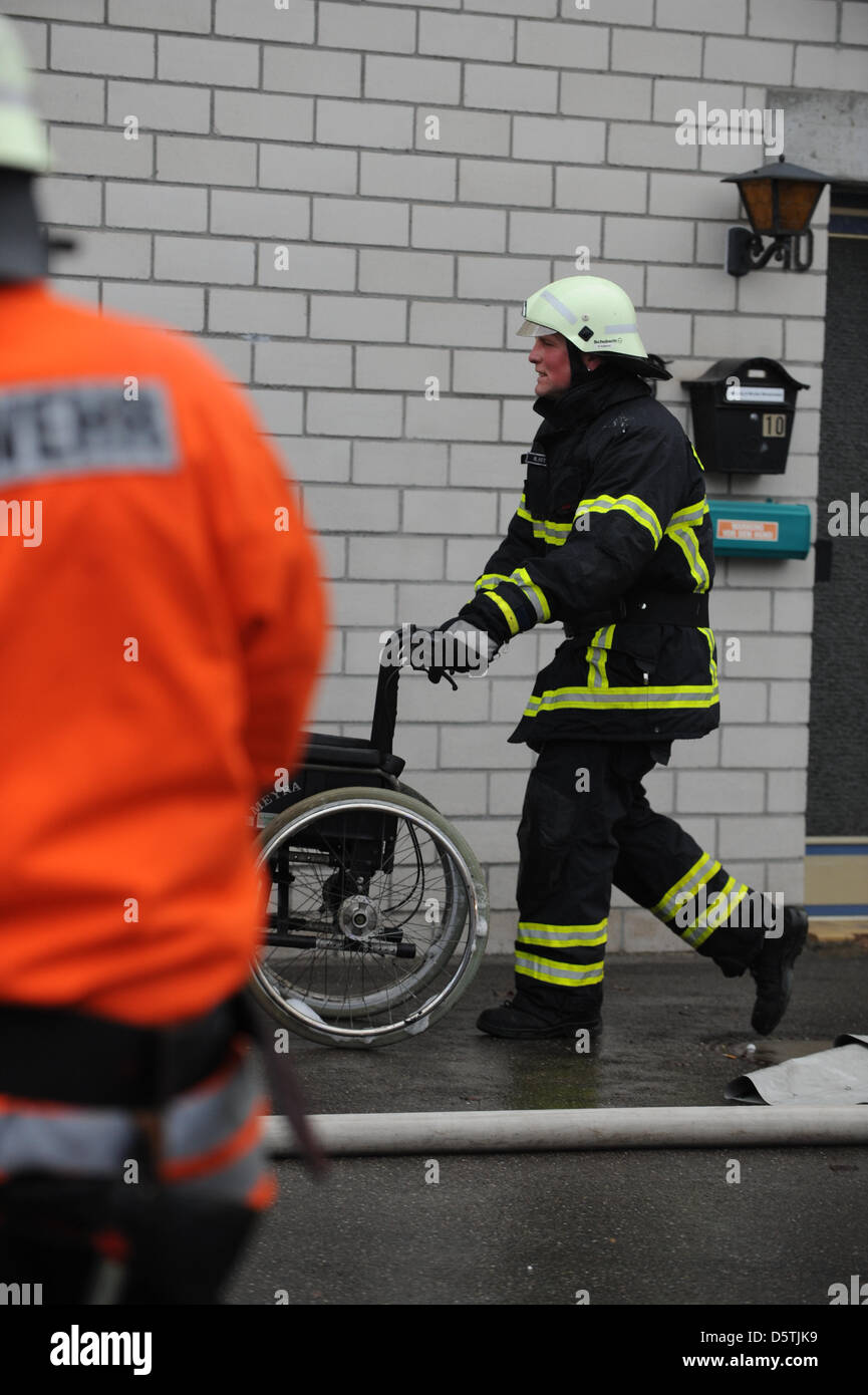 A fireman pushes a wheelchair during a fire at a sheltered workshop in ...