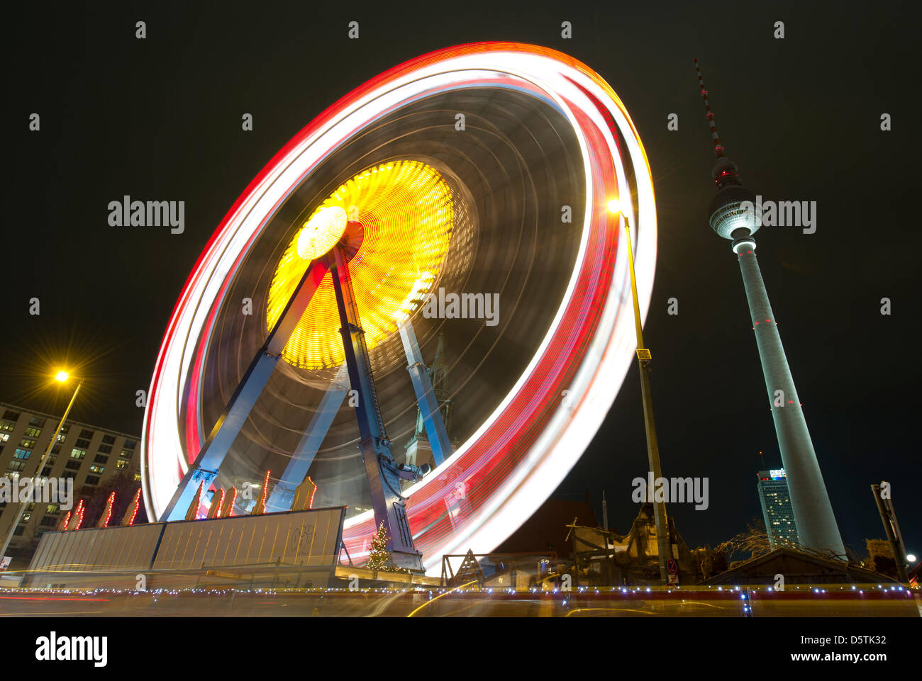 The TV tower is seen behind a moving Ferris wheel in Berlin, Germany ...