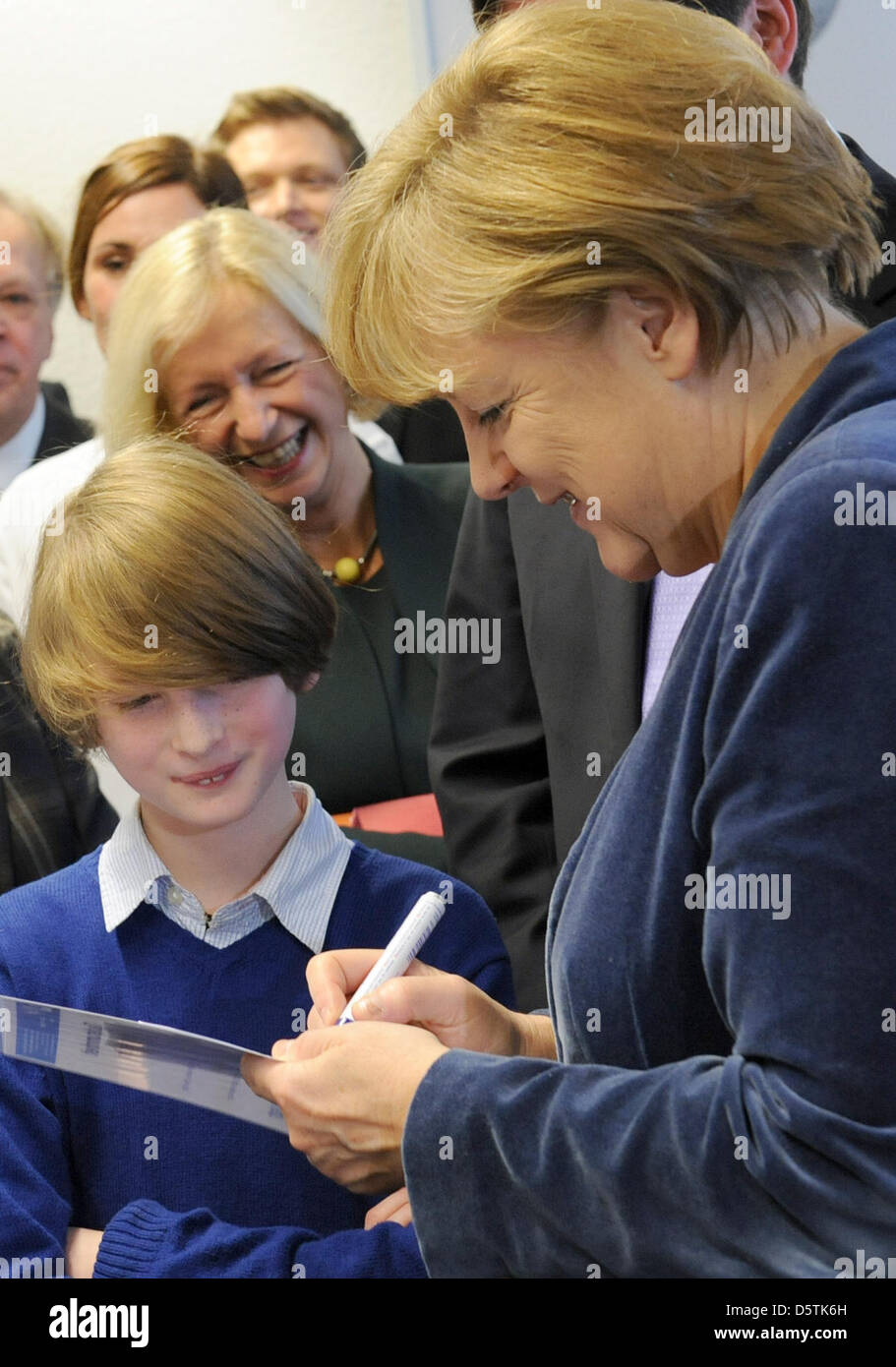 German Chancellor Angela Merkel signs an autograph for ten-year-old ...