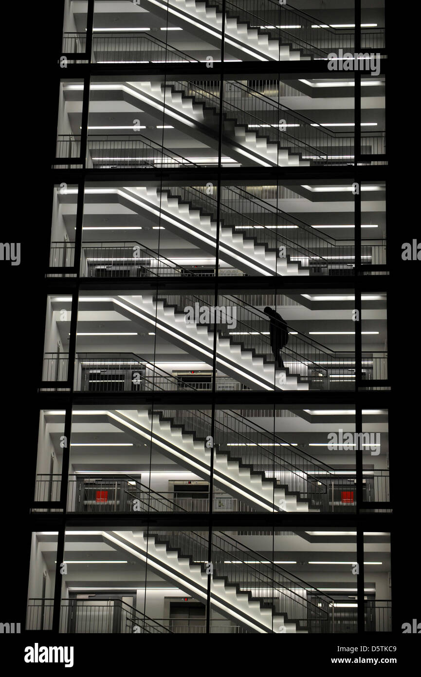 A person walks up a lighted staircase in an office building in Munich ...