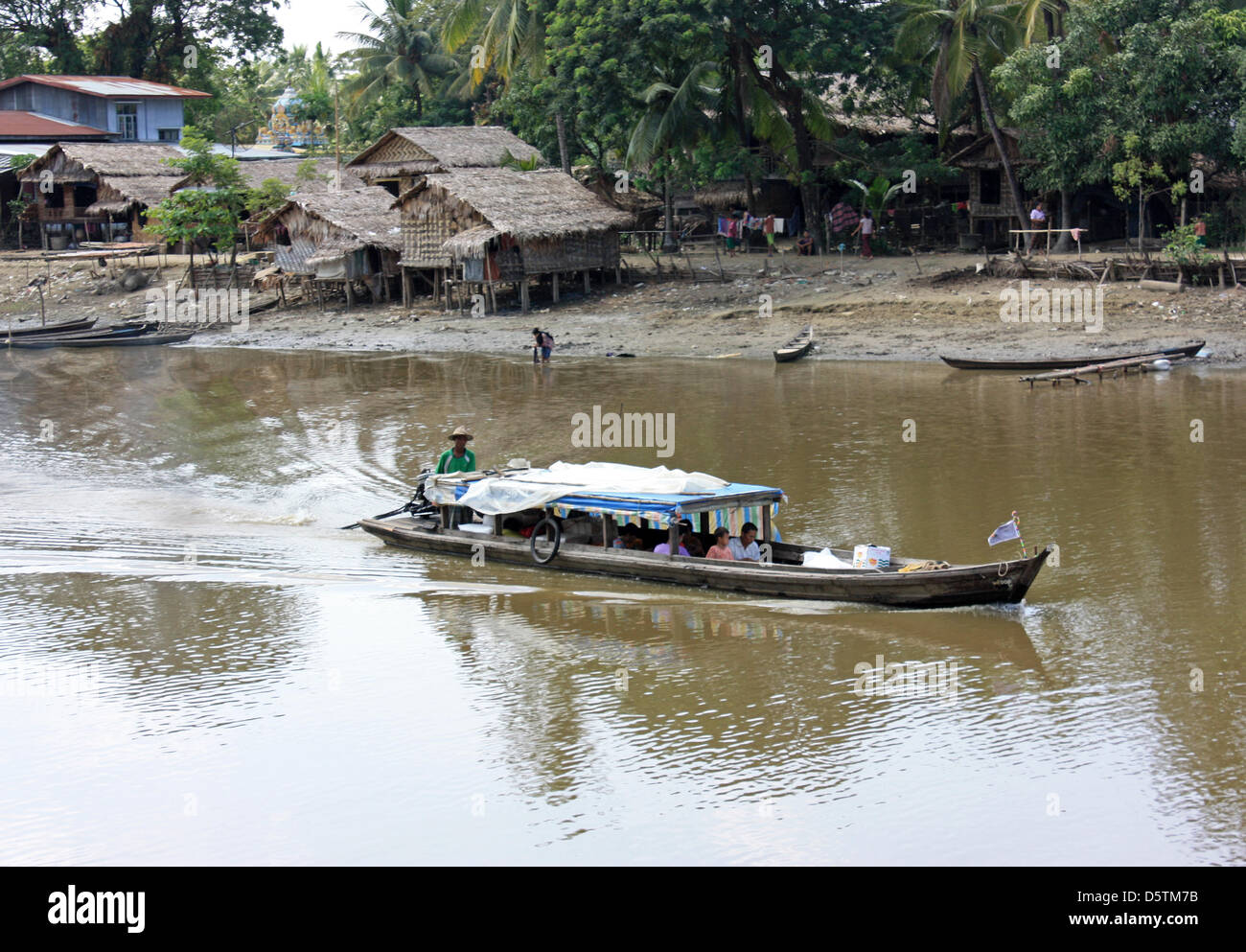 View of a boat on a river in front of a hut in Bago (Pegu), Myanmar, 23 ...