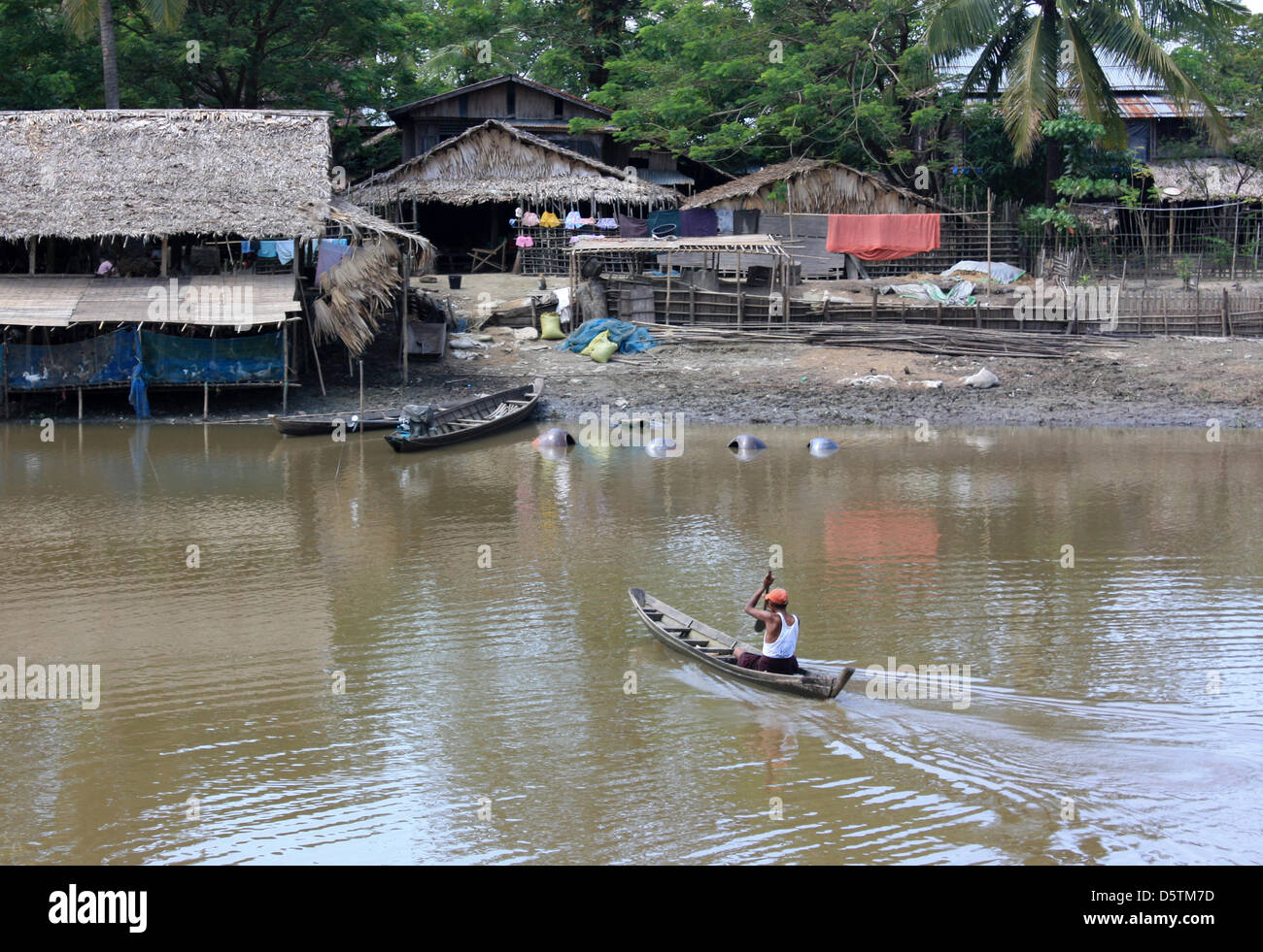 View of a boat on a river in front of a hut in Bago (Pegu), Myanmar, 23 ...
