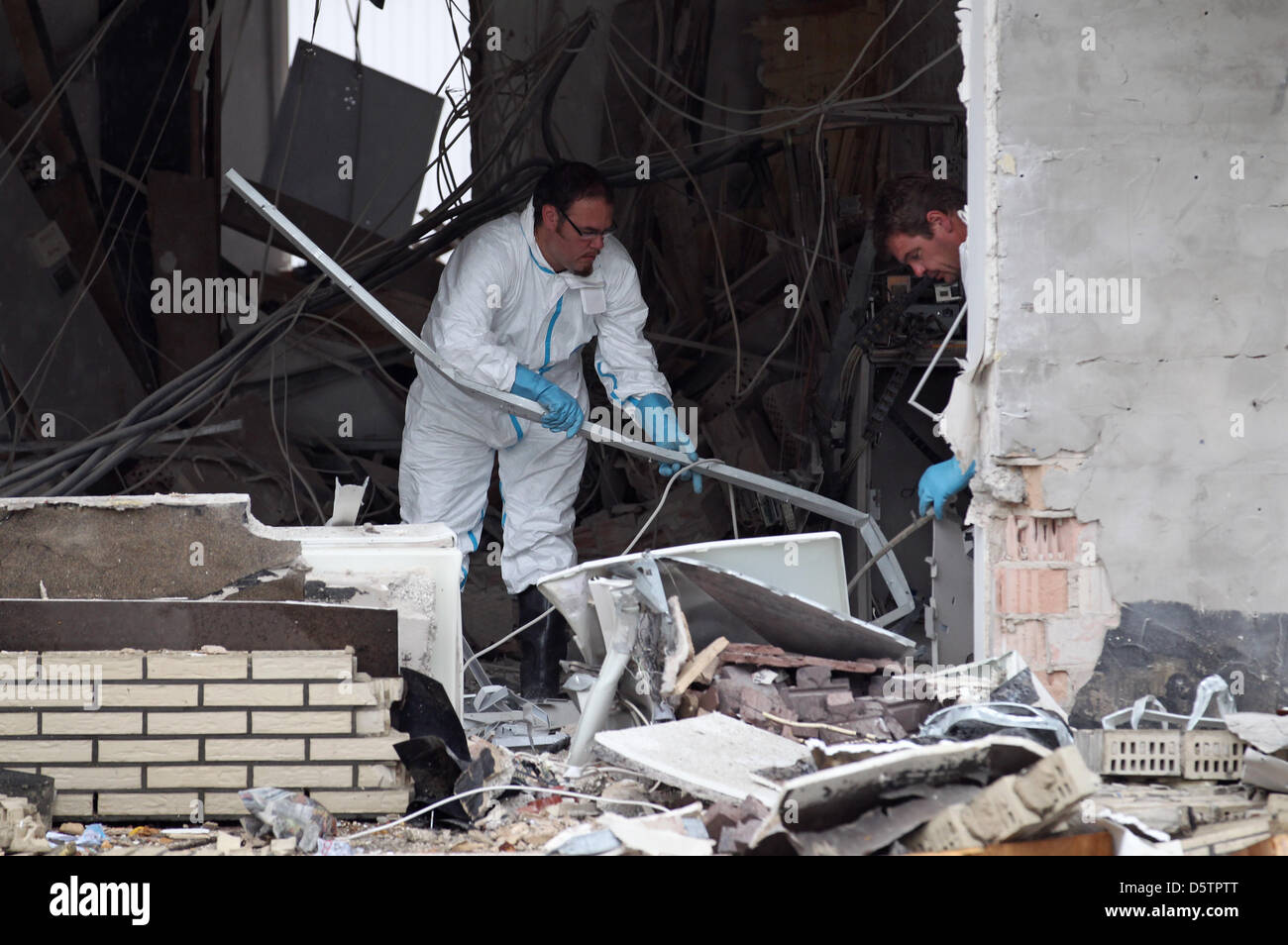 Forensic scientists examine debris after an explosion in a bank in ...