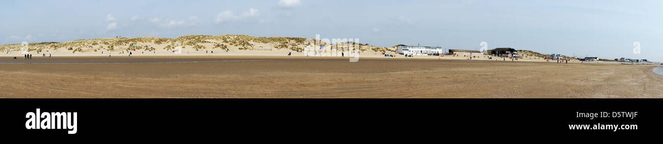 camber sands bank grass blue sky golden clouds buildings houses people ...