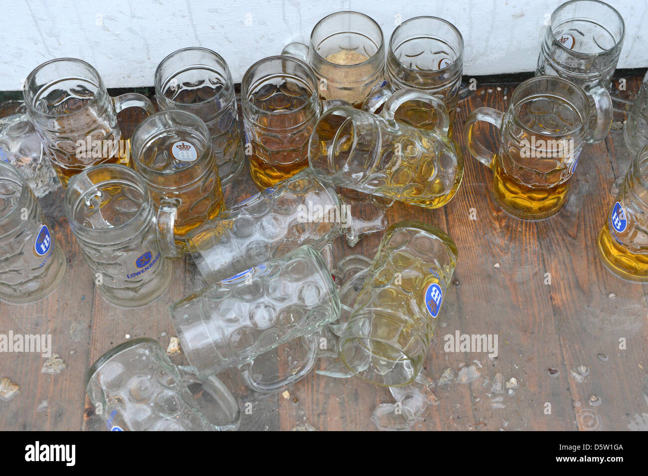 Empty and broken glasses of beer stand in the rain at the garden of ...