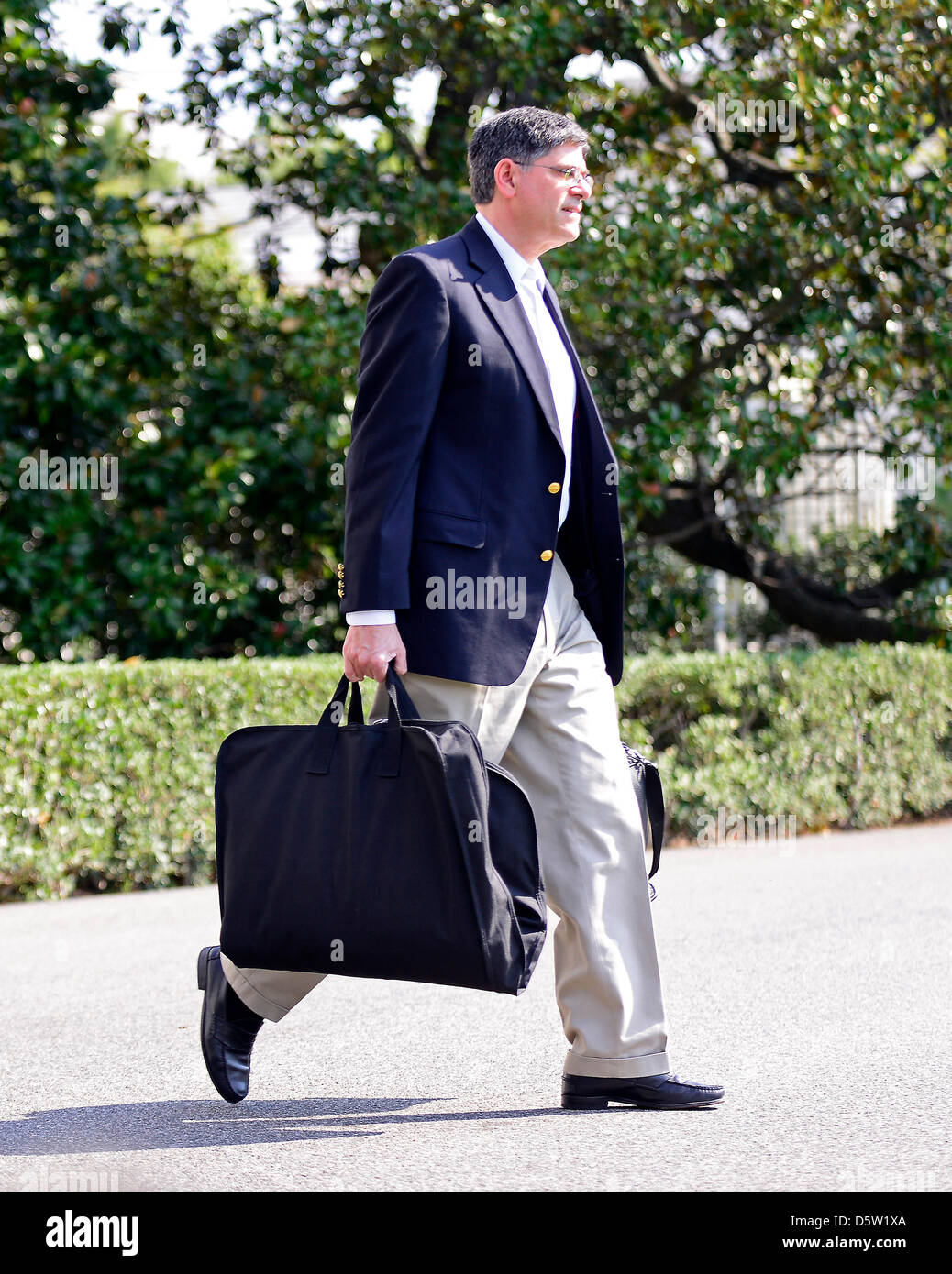 White House Chief of Staff Jacob Lew carries his bags as he walks to ...