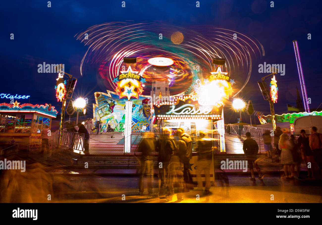 The 'Skater' rollercoaster illuminates the night at the Oktoberfest in ...