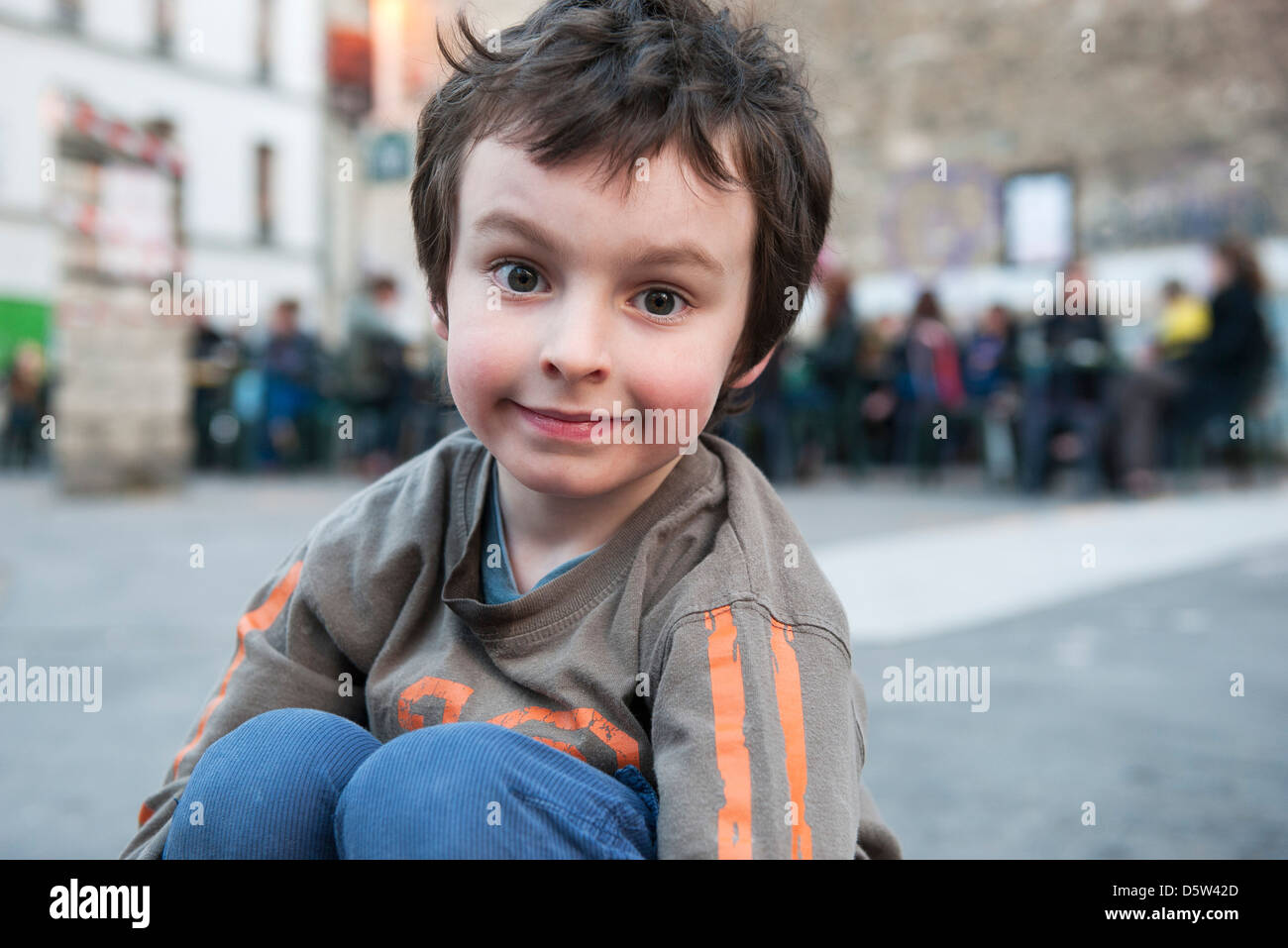 Boy sitting outdoors in urban setting, portrait Stock Photo - Alamy