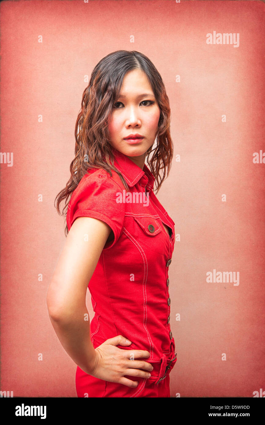 A Thai female model wearing a red shirt posing with red paper texture ...