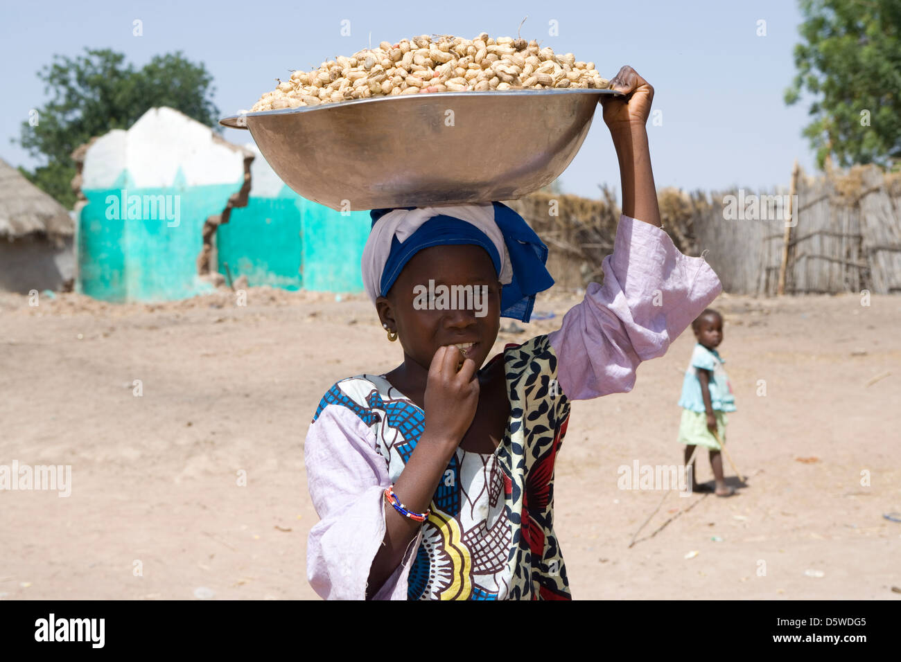 Gambia: Sambel Kunda village / girl carrying groundnuts Stock Photo - Alamy