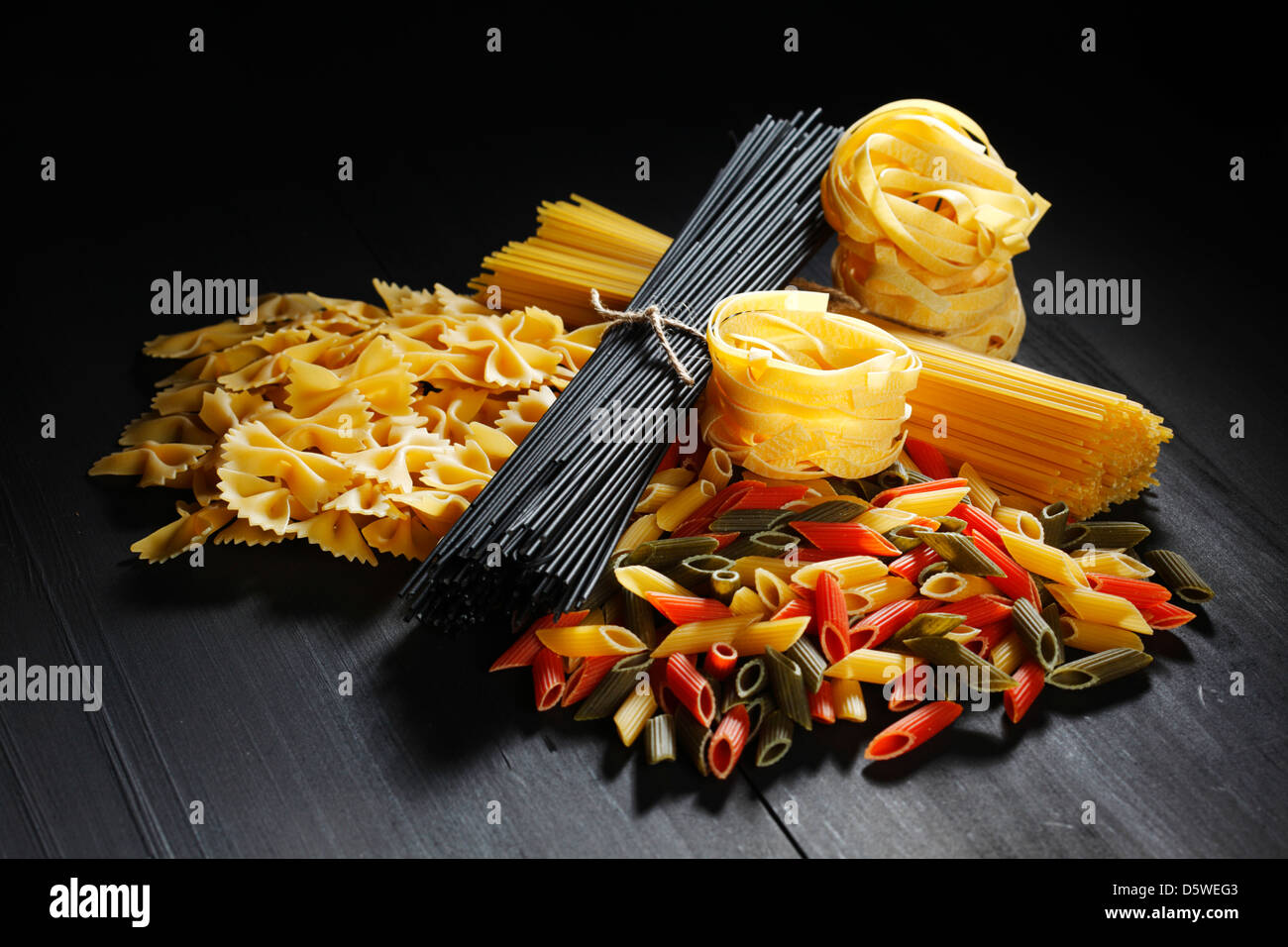 Variety of types and shapes of Italian pasta on black table Stock Photo ...