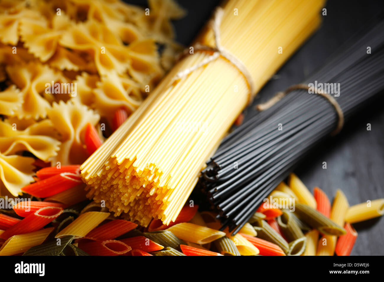 Variety of types and shapes of Italian pasta on black table Stock Photo ...